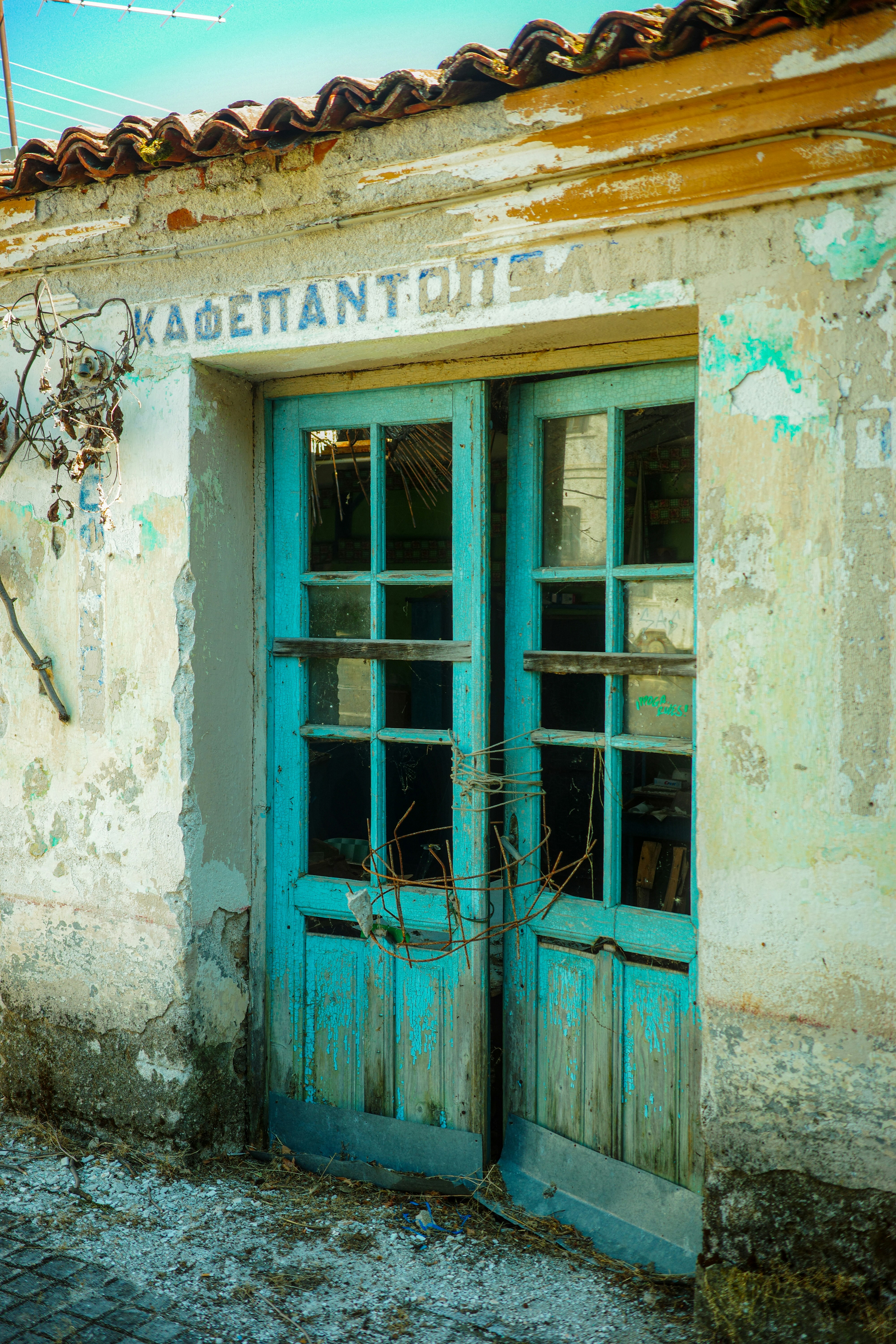 Weathered turquoise doors in a sunlit seaside facade