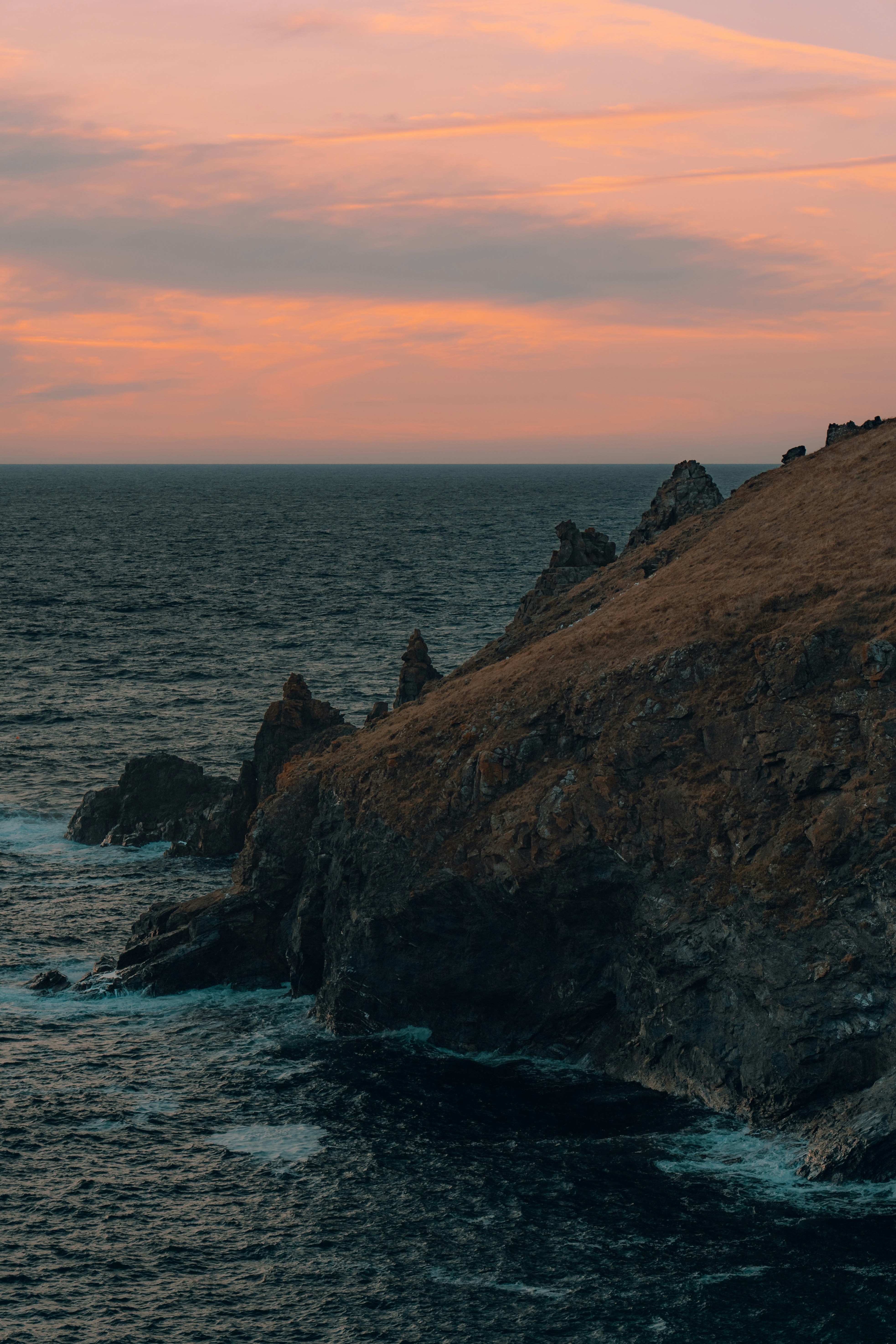 Sunset Clash: Rugged Coastline Meeting the Quiet Sea