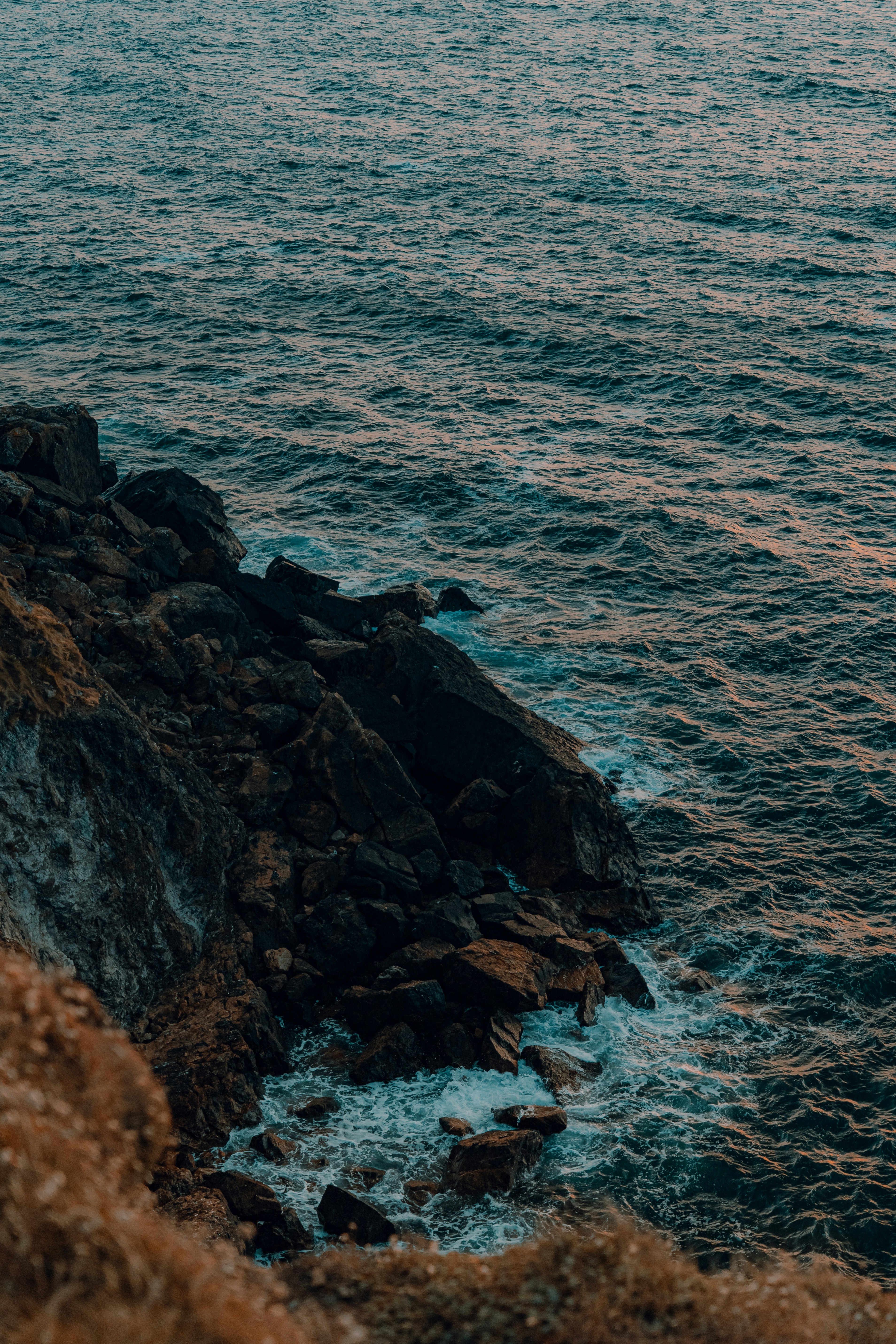 Cliffside Edge Meeting the Ocean at Dusk