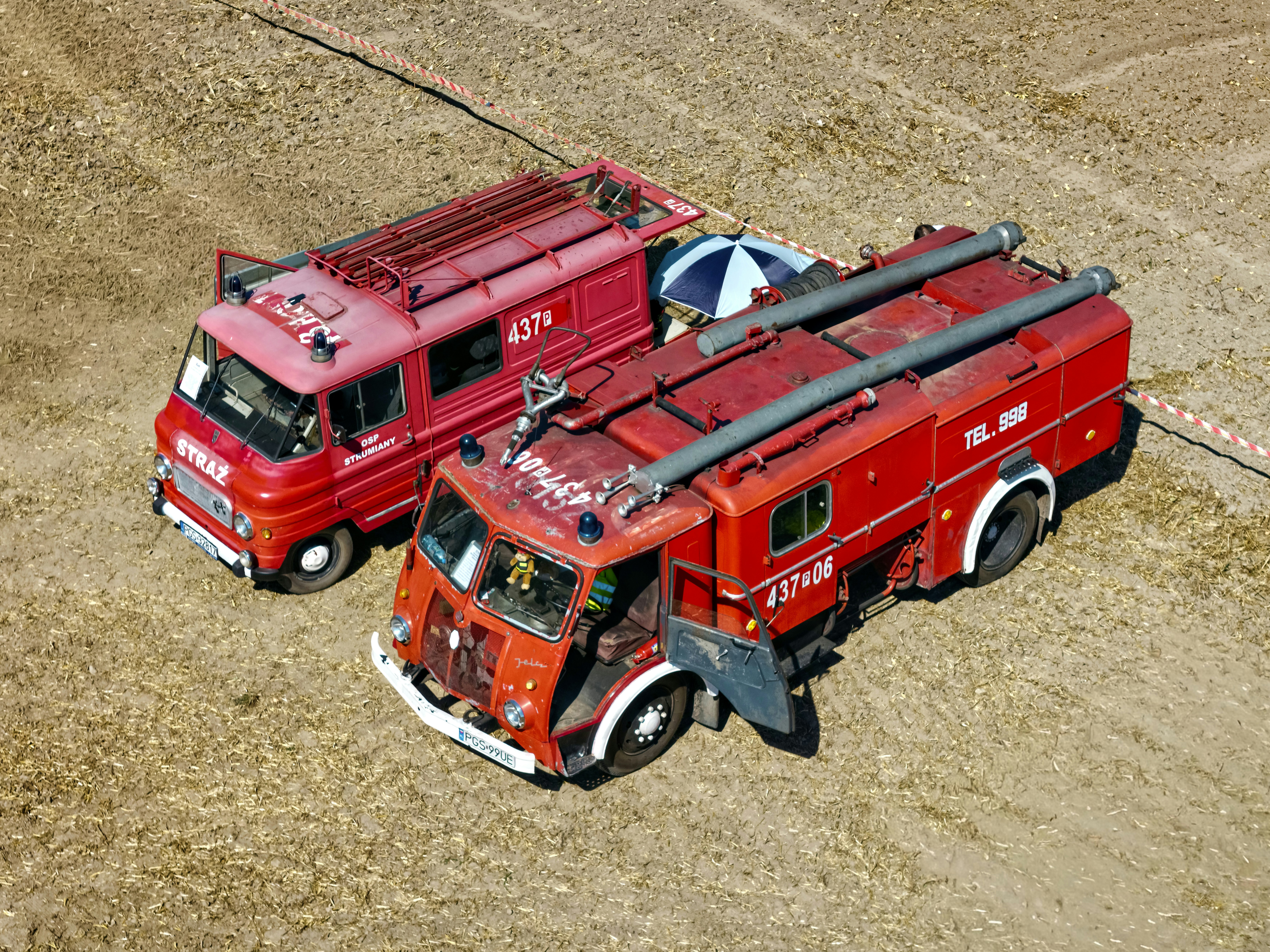 Red Air: Aerial View of Dual Fire Appliances Resting on Gravel