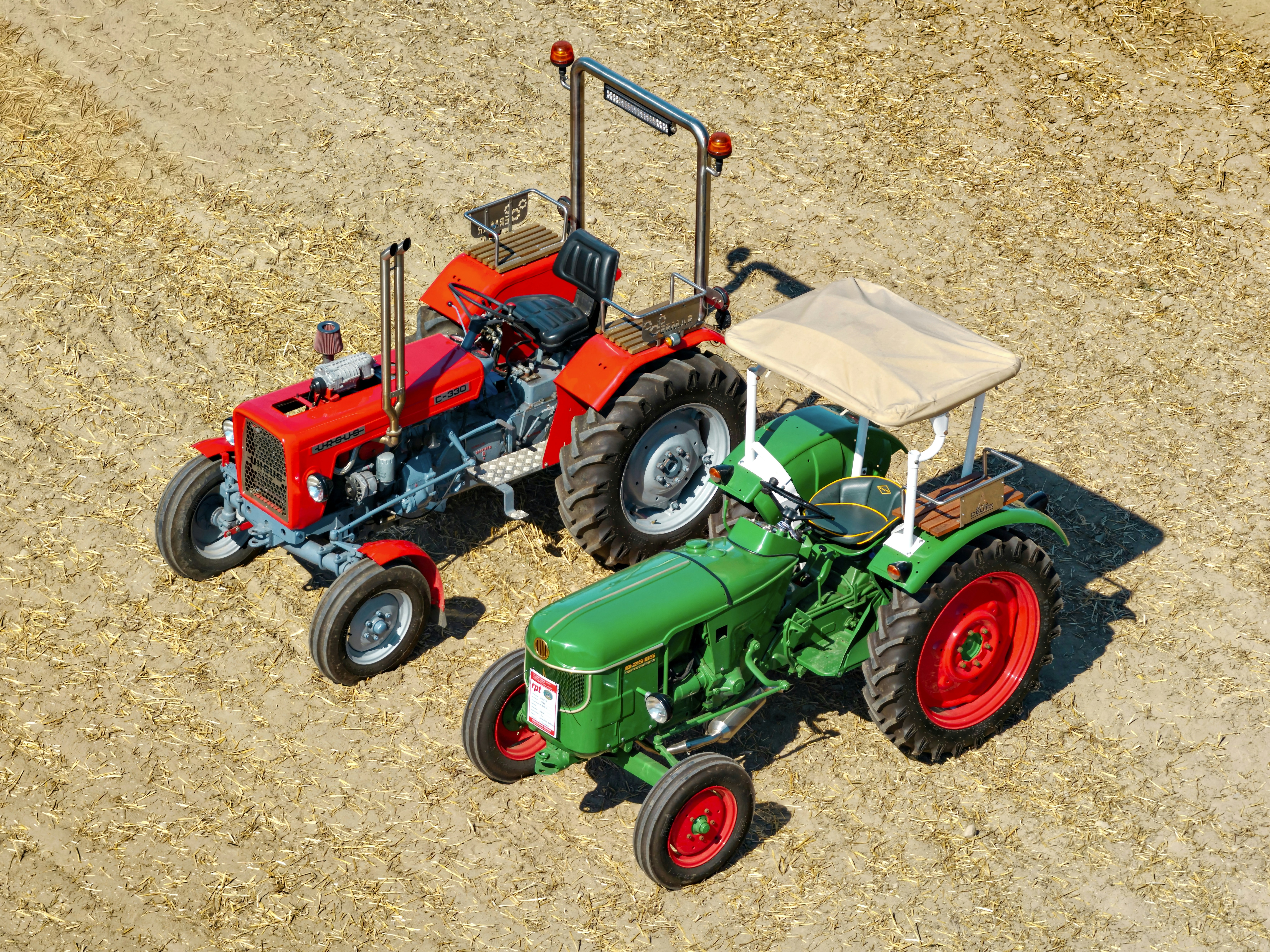 Red and Green Tractors Resting Amid Dry Field