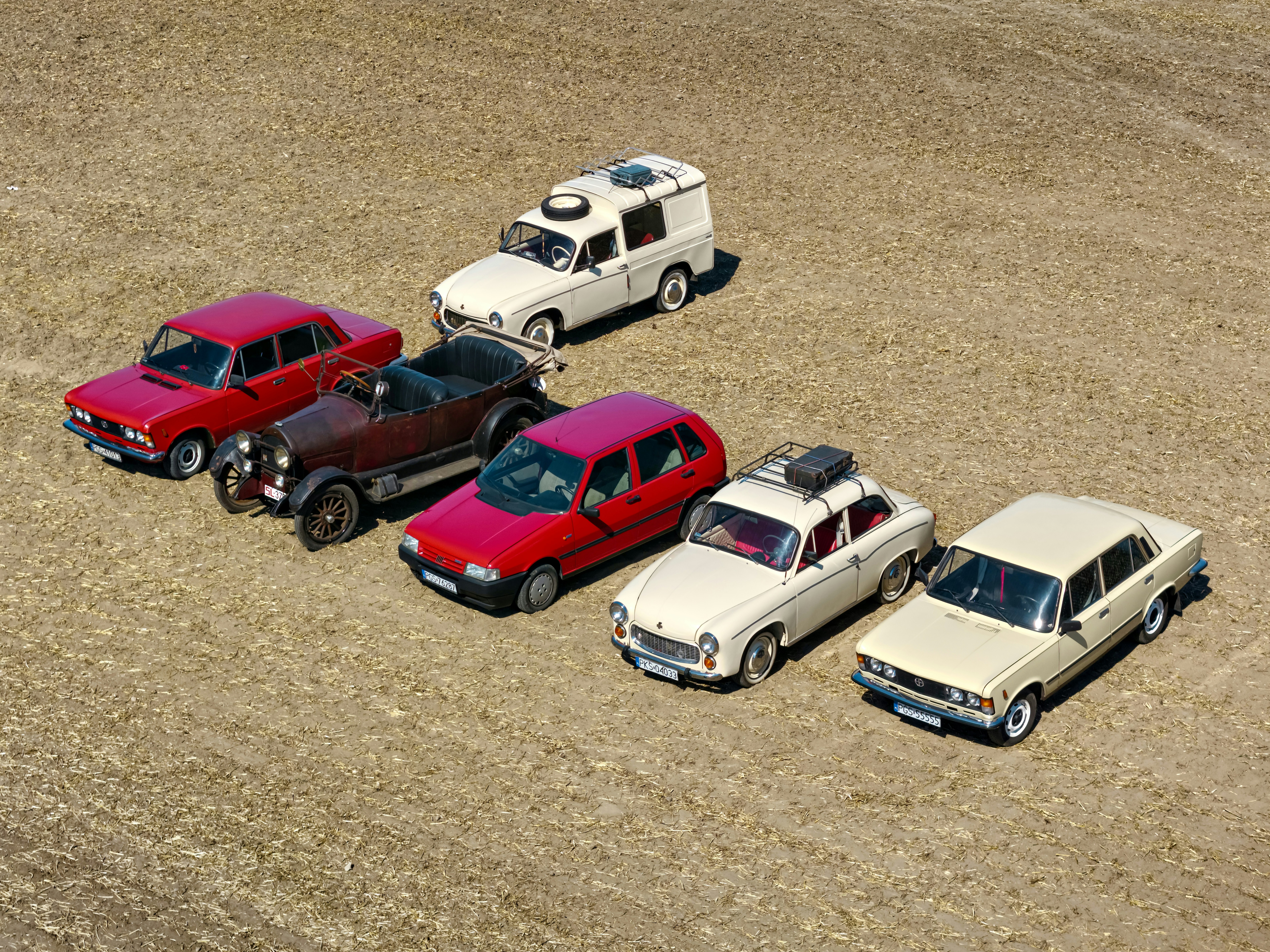 Row of Vintage Sedans Resting on Sunlit Desert Bed