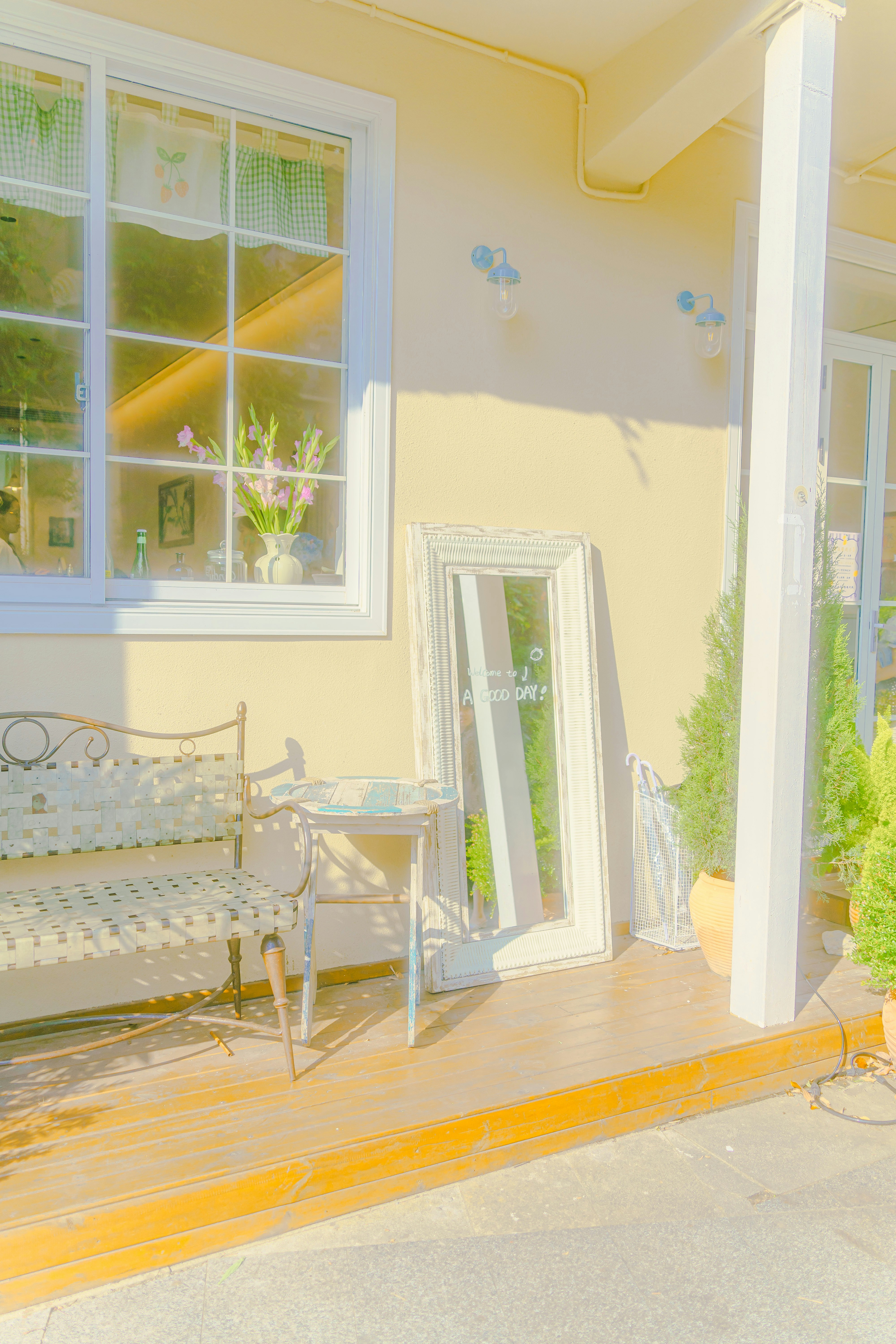 Sunlit Terrace with Chalky Yellow Facade and Reclaimed Mirror