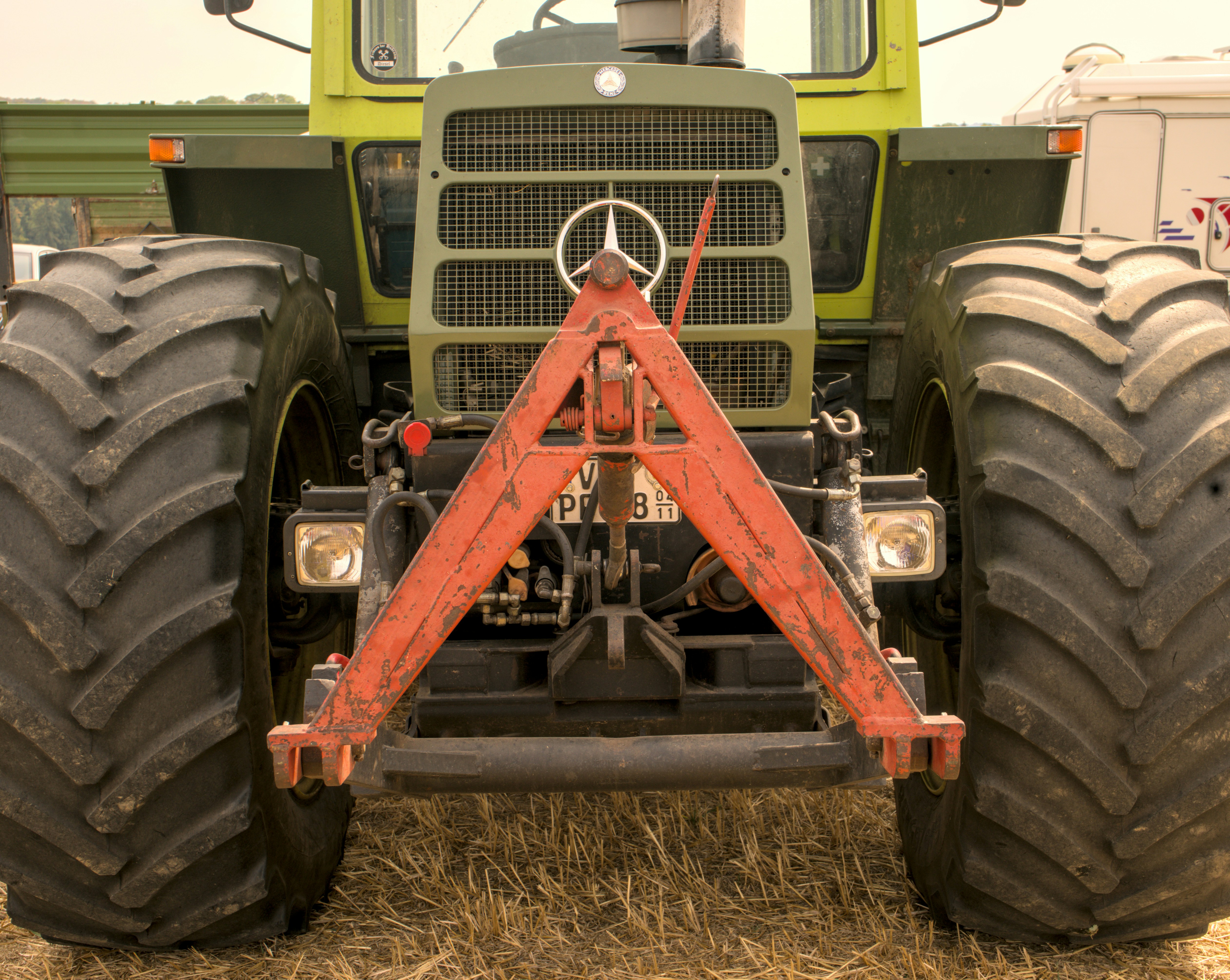 Front Loader Focus: A Tractor’s Red Outreach Reaches for the Sky