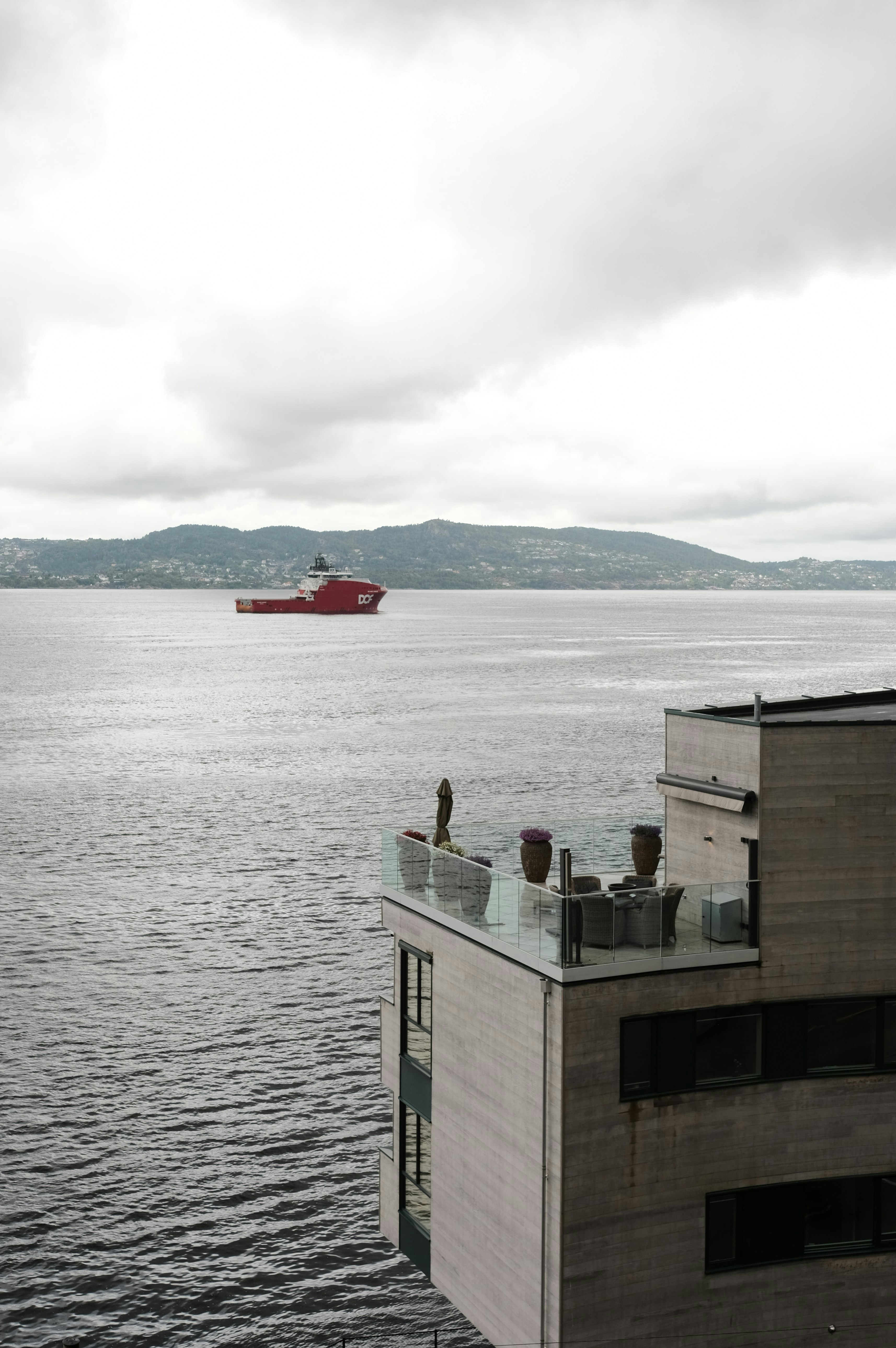 Terrace Overlooking the Sea: A Red Vessel Drifts by