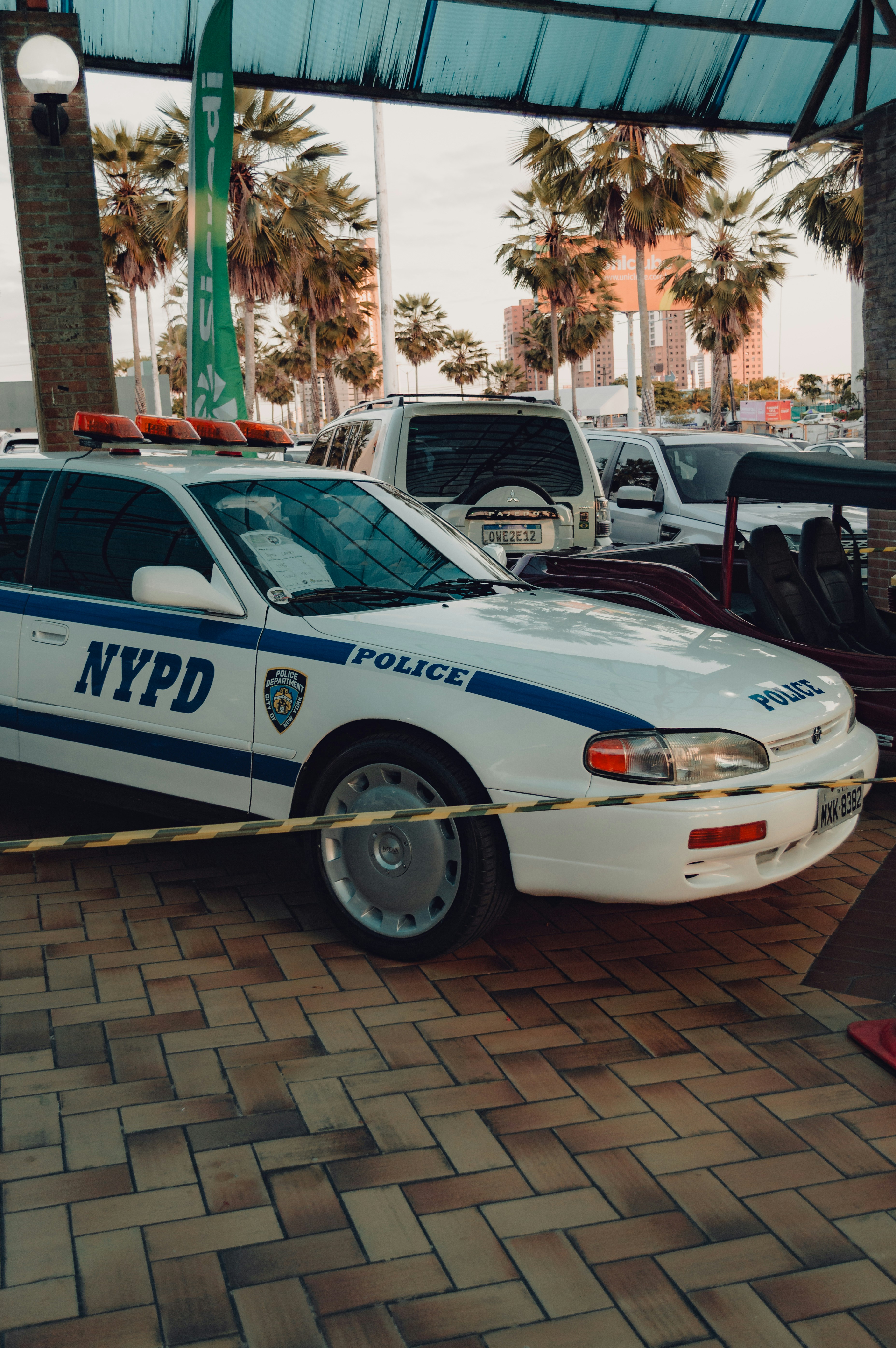 NYPD Cruiser Under A Canopy, Harbor District Backdrop