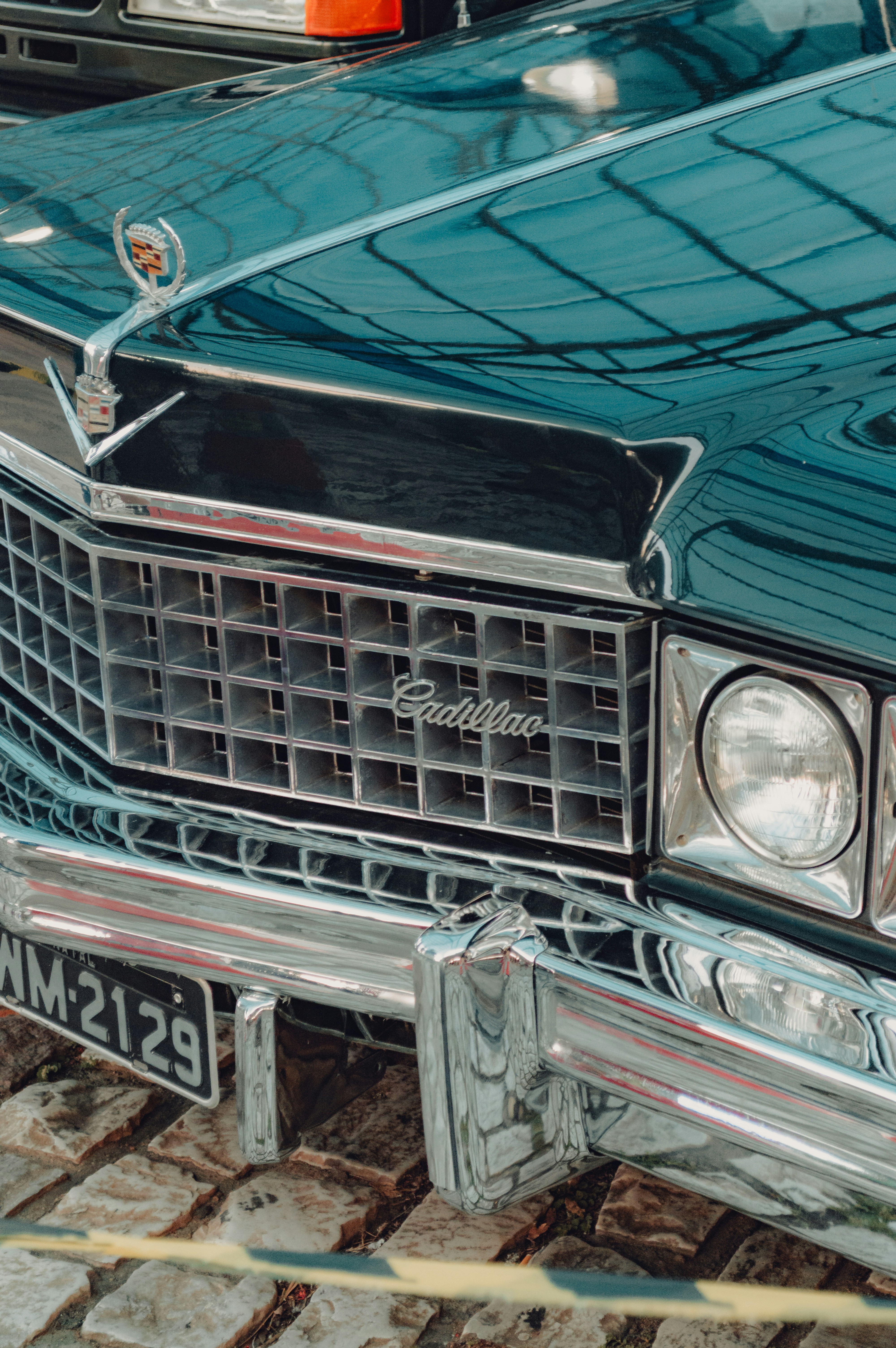 Gleaming Cadillac Grille Under Reflective Teal Hood