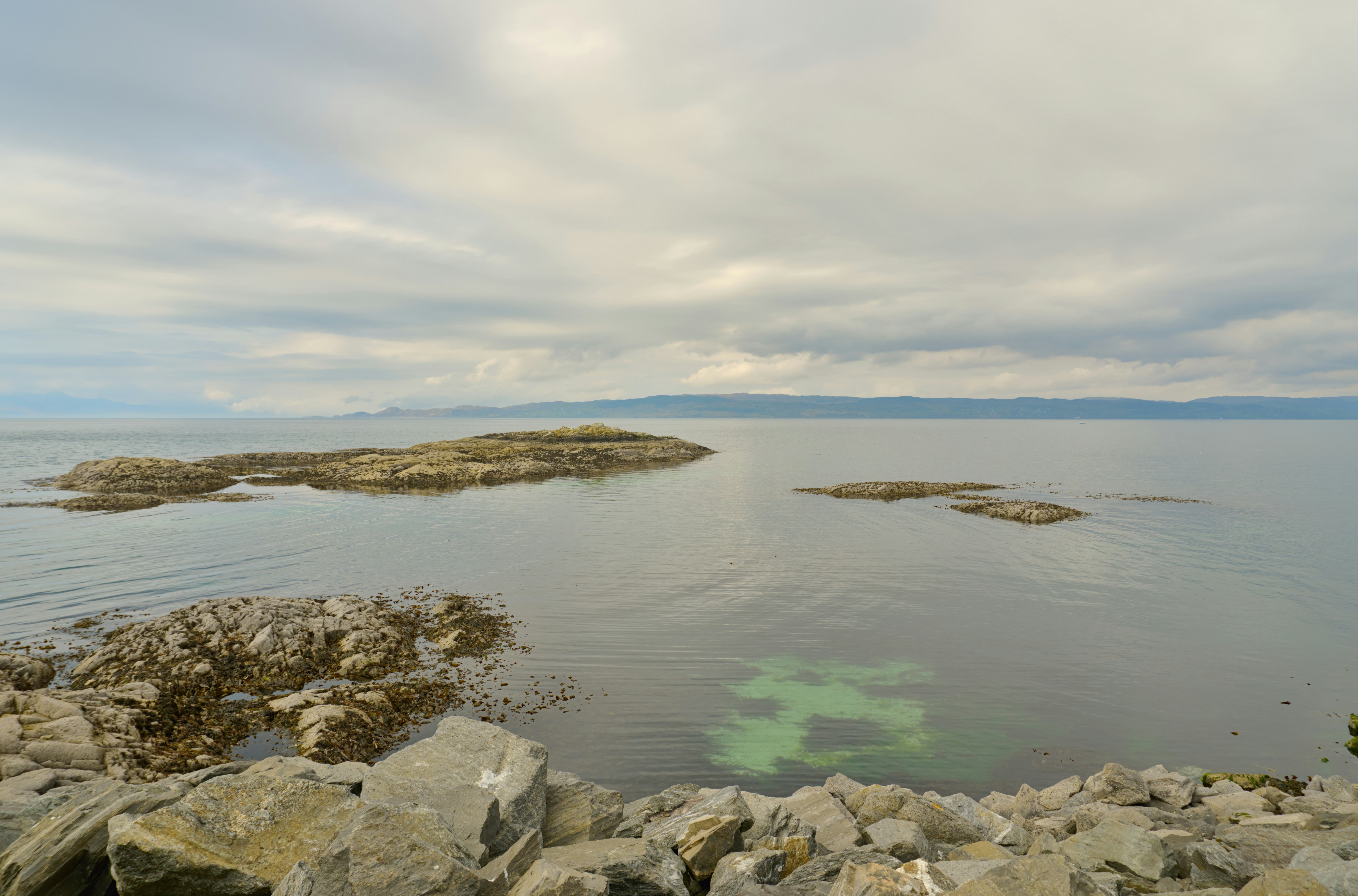 Stone-Rimmed Shore Beneath a Quiet Cloudscape