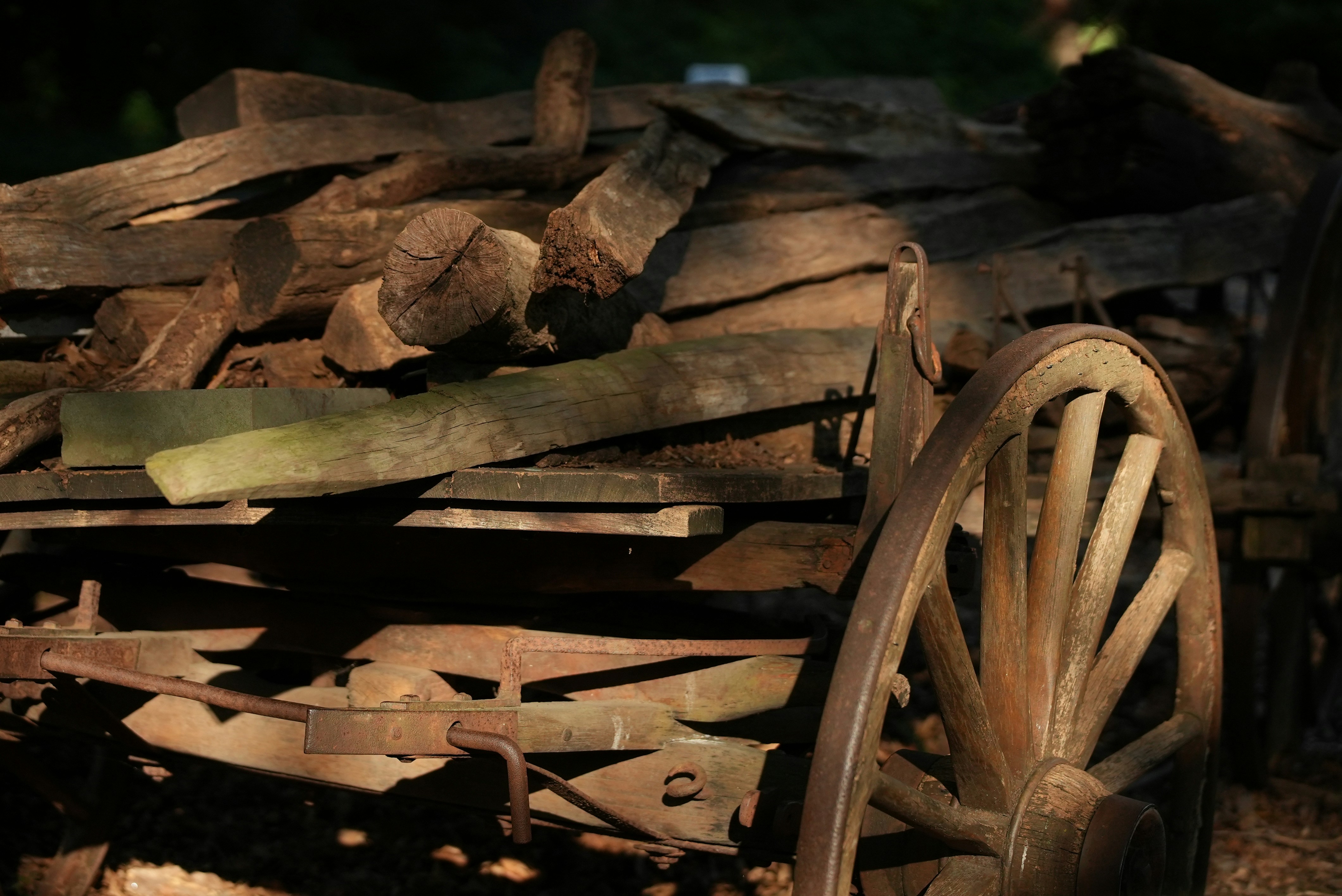 Wheeled Wagon Resting Against a Stack of Weathered Lumber
