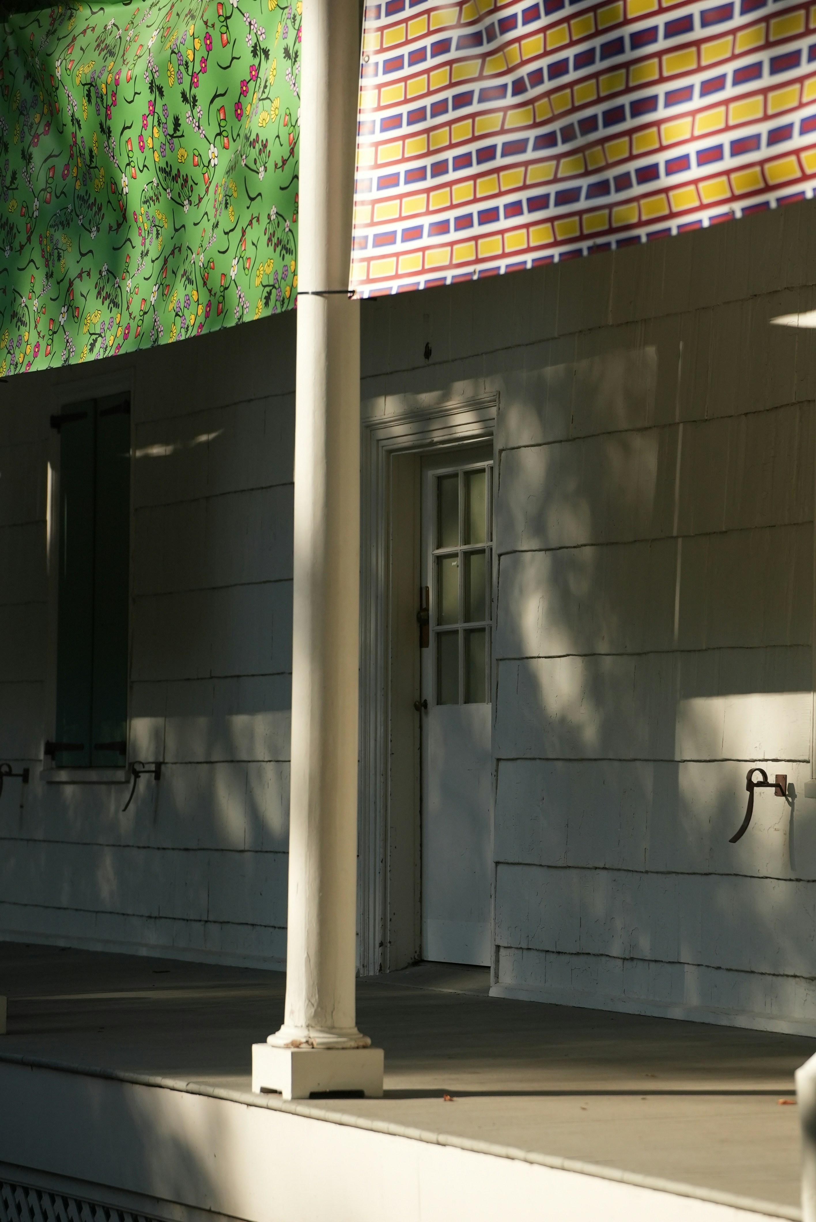 Sunlit Porch with Dappled Shadows and Colorful Canopy
