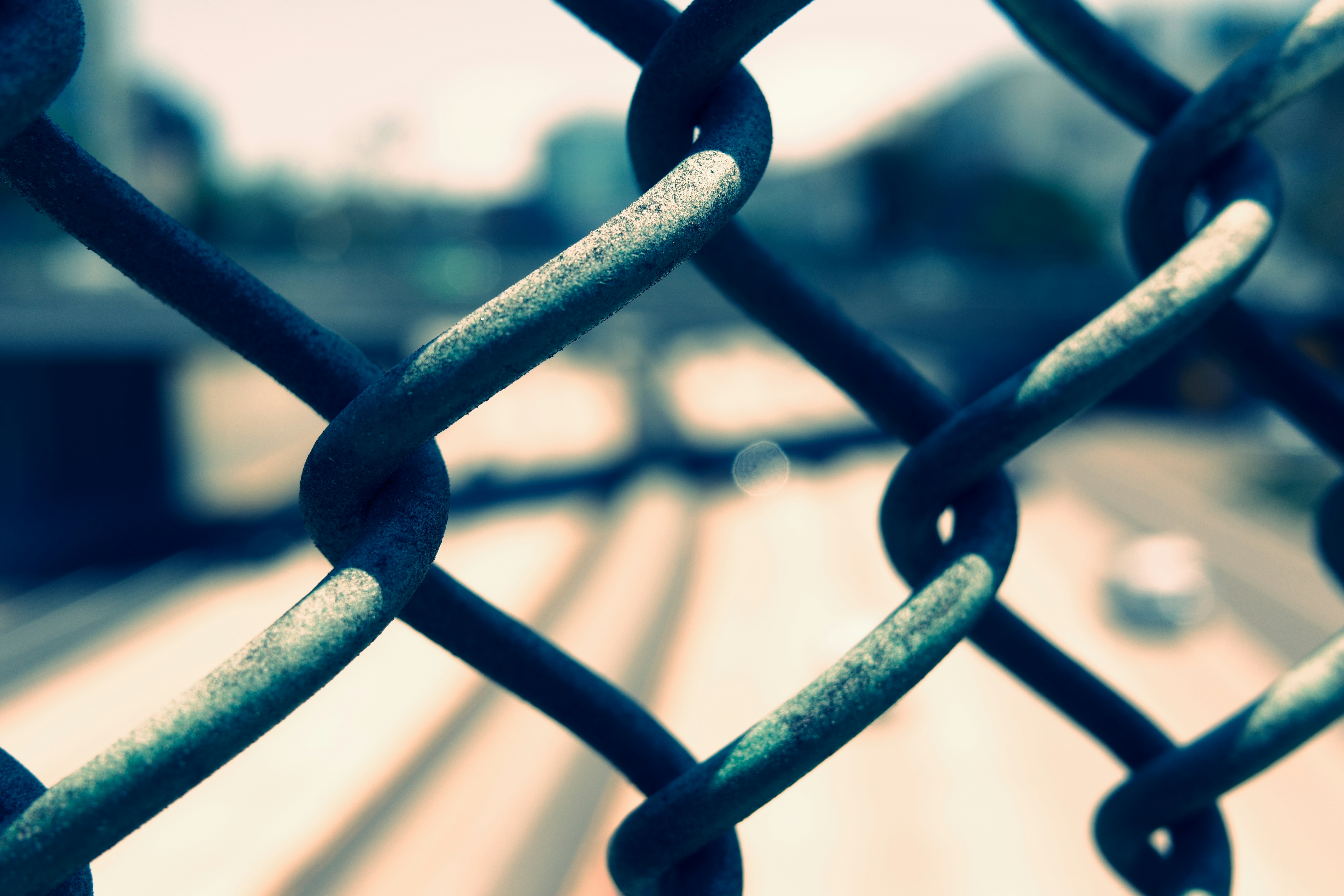 Close-View of Weathered Chain Links Framing a Quiet Industrial Background