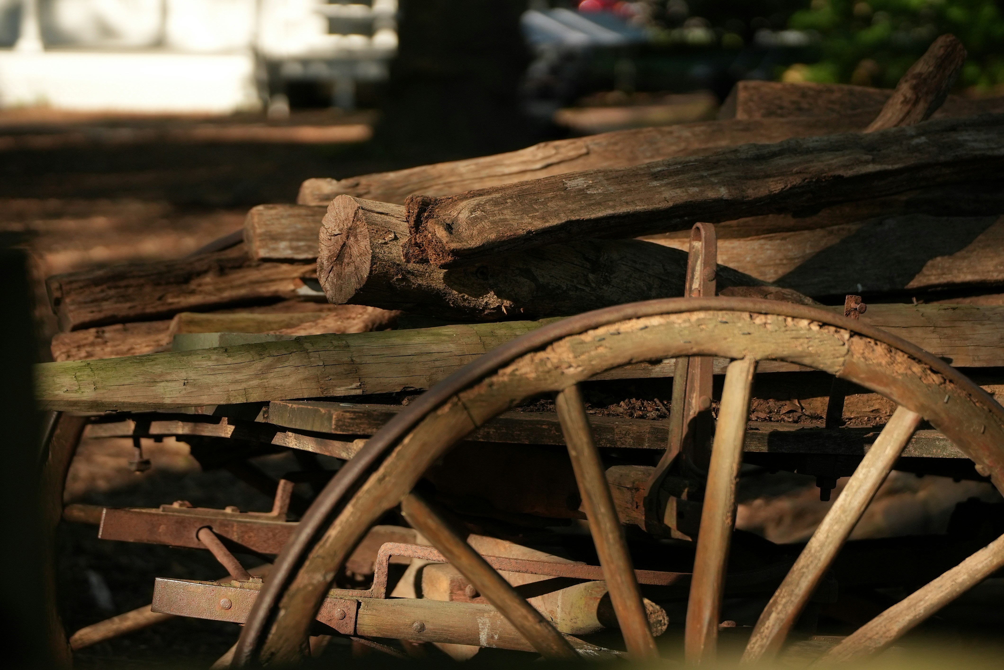 Weathered Wheel and Woodpile in Quiet Sunlit Corner