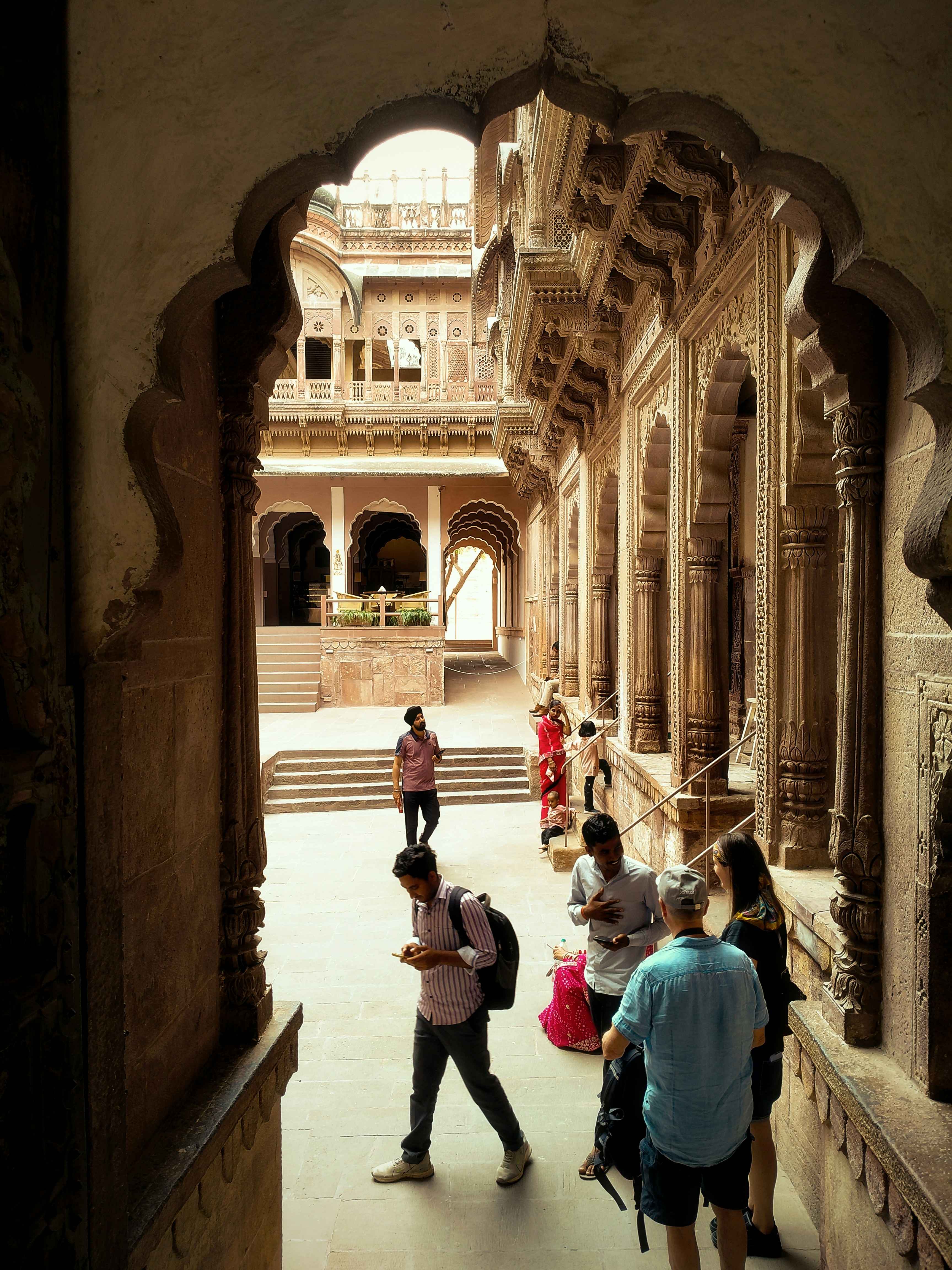 Courtyard in Amber Fort: People under Ornate Carved Archways