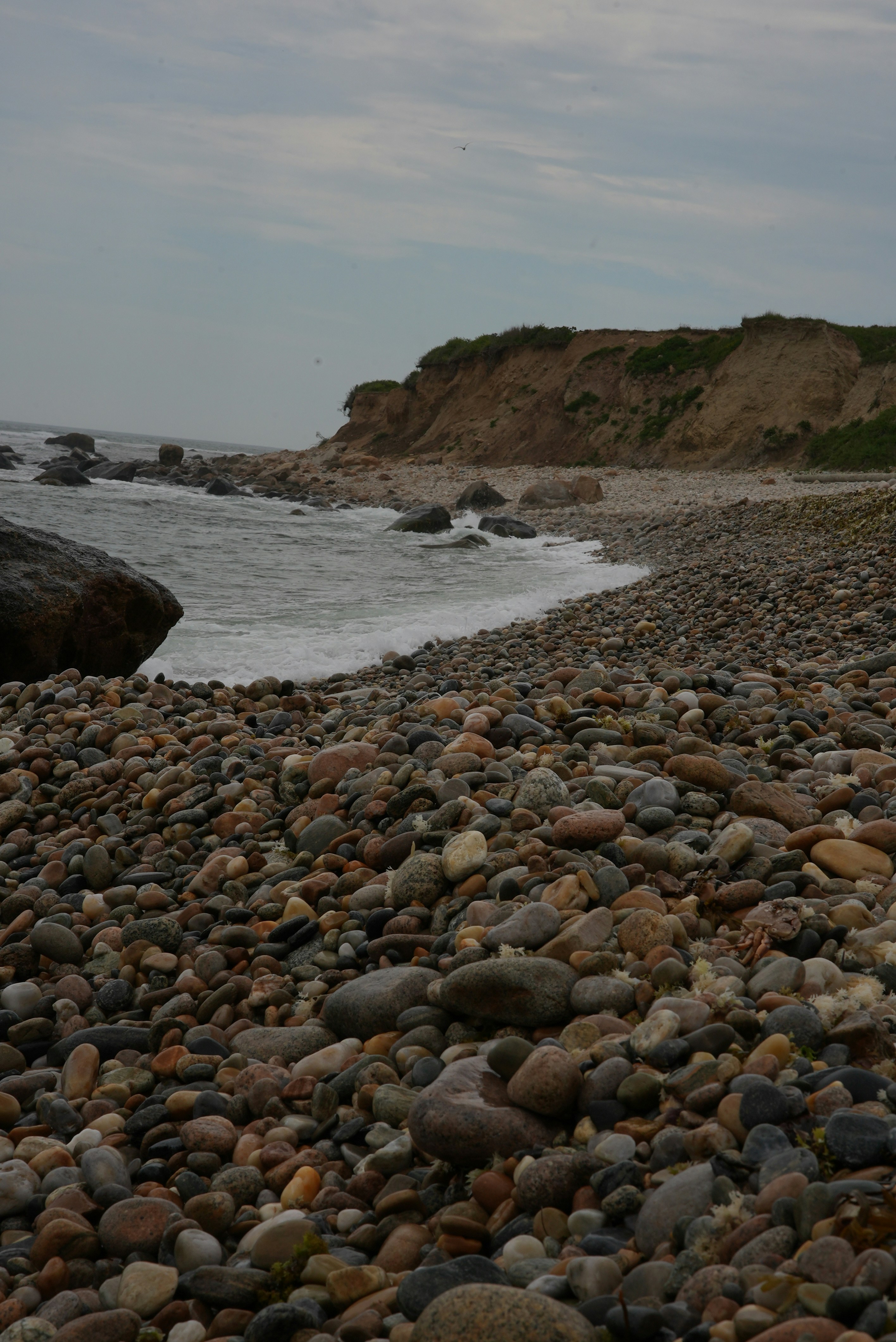 Pebble shore beneath a weathered cliff