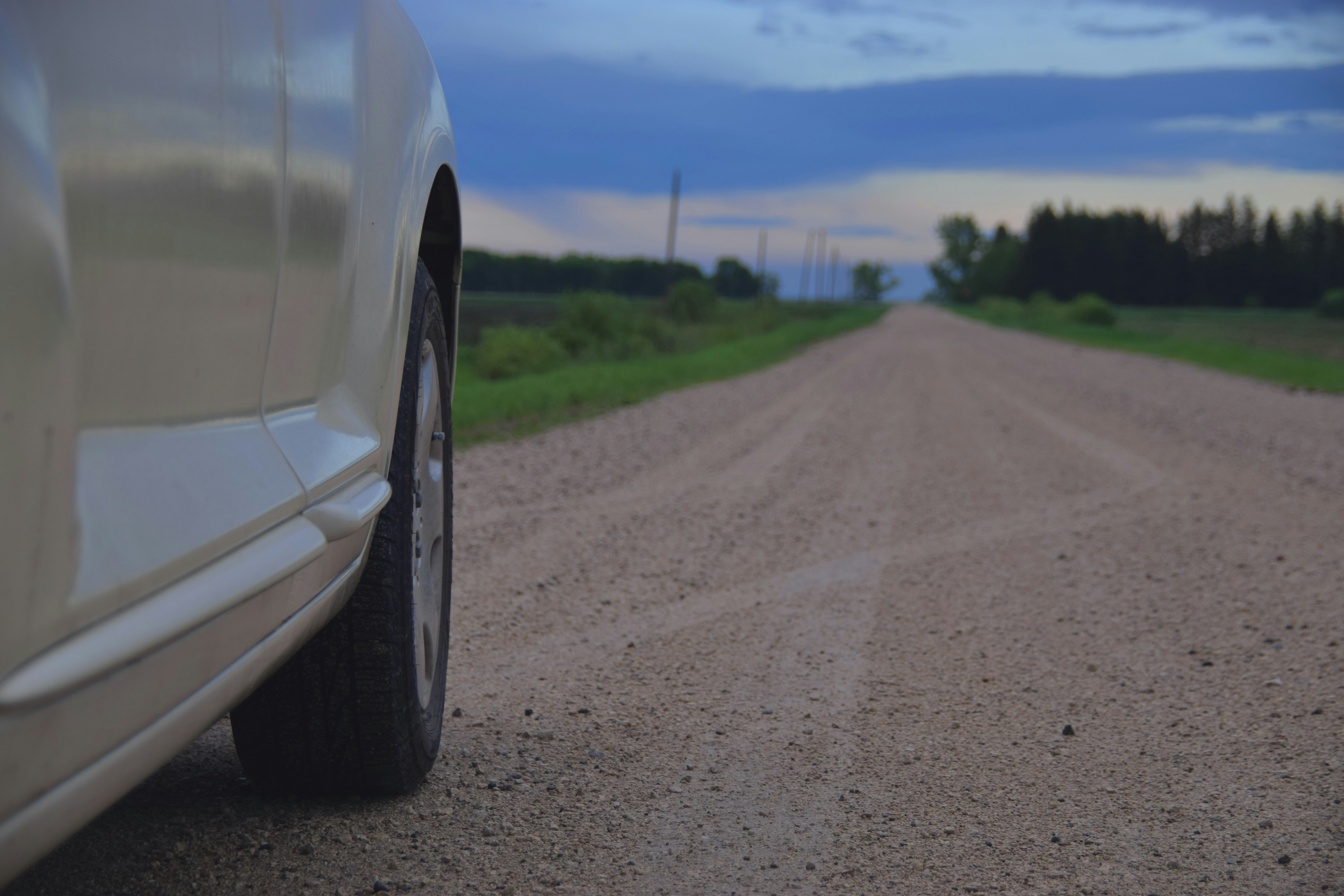 On the Long Road: A Car's Shadow Leading into the Horizon