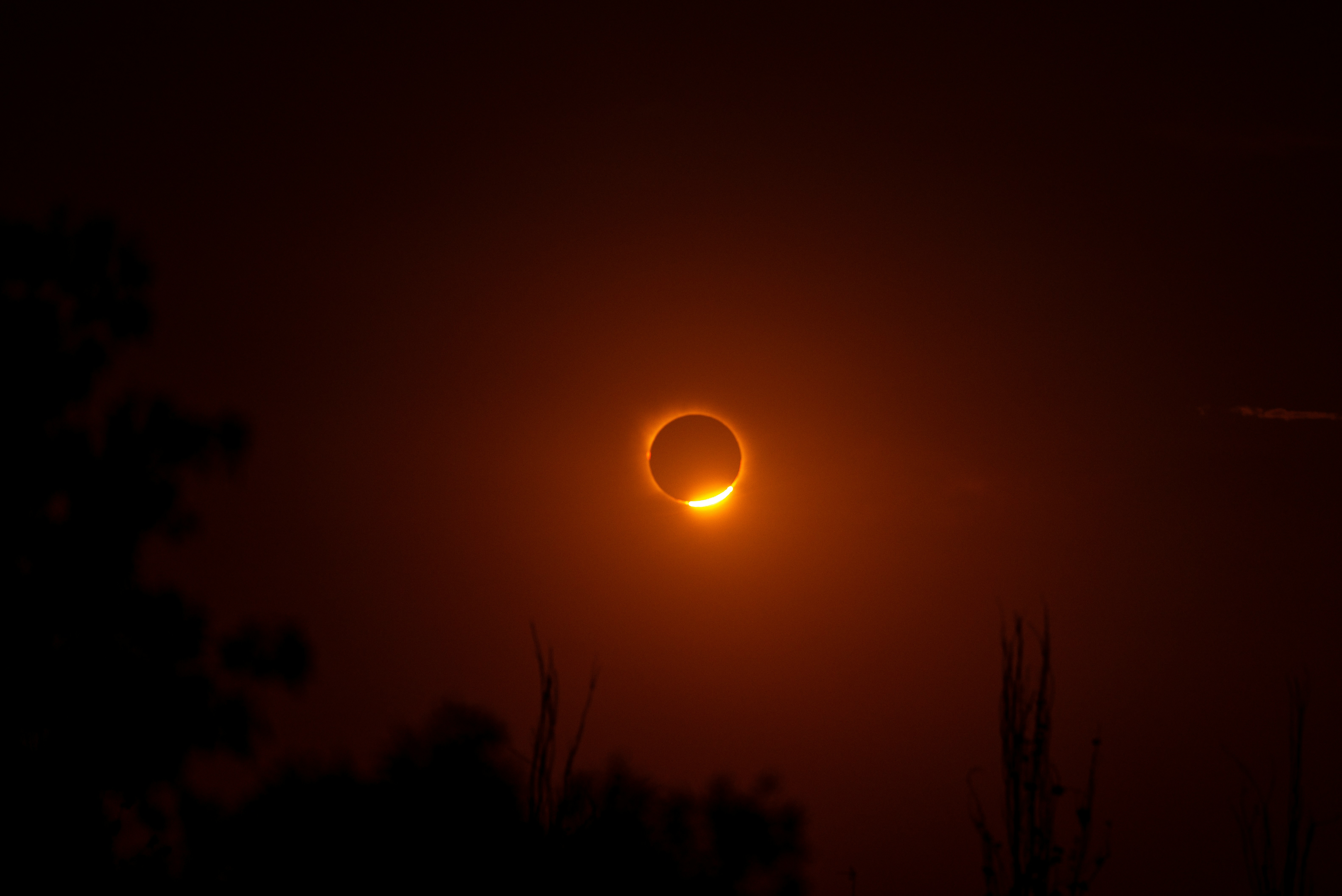 Solar Eclipse Halo: Crescent Sun Emerges Through Nightfall