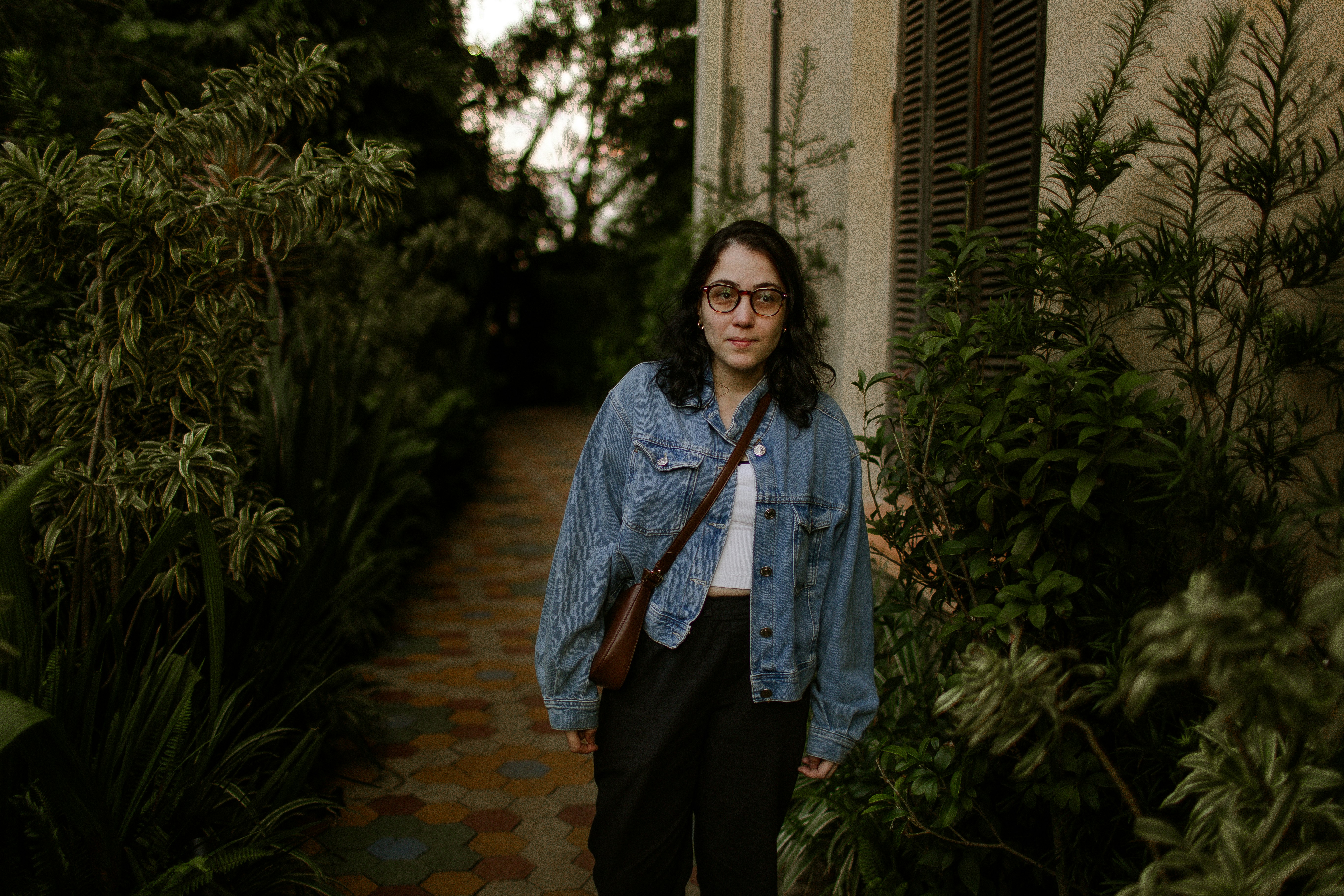 Denim-Toned Walk: A Quiet Portrait in a Garden Corridor