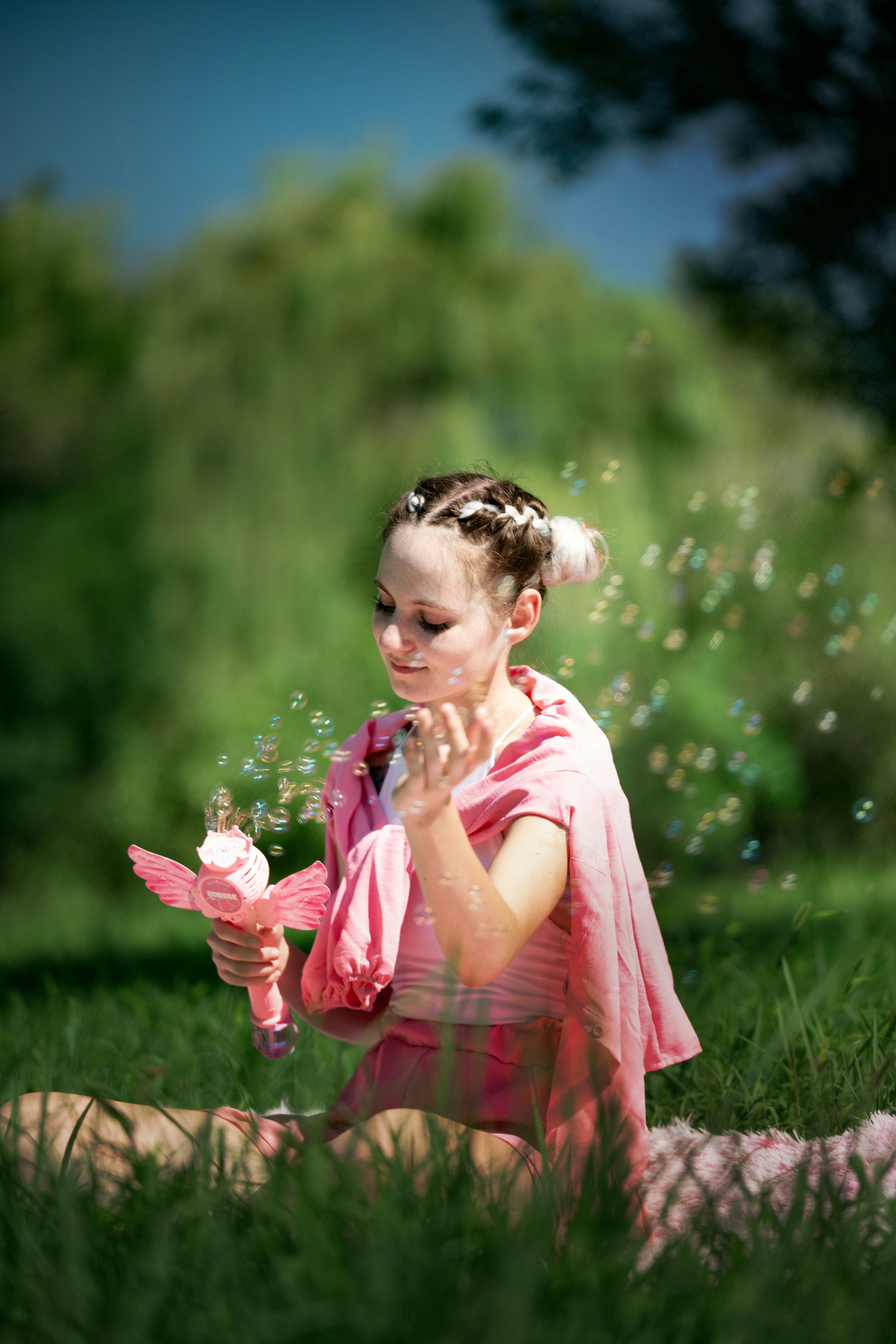 Bubble Burst of Pink Play: A Girl with a Bubble Wand in Sunlit Grass