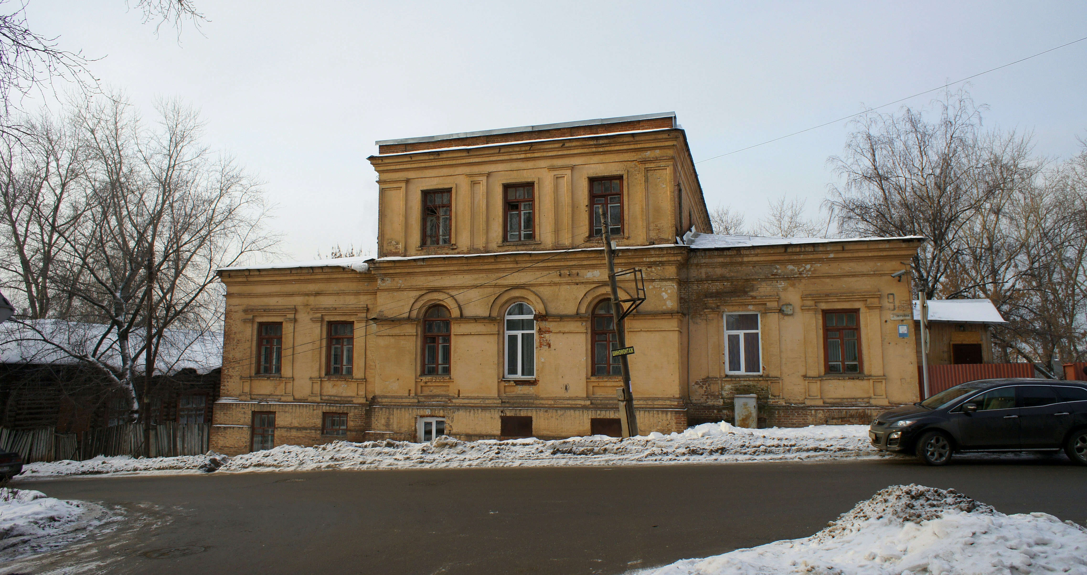 Ancestral Facade: The Weathered Mansion Beside a Snow-Coated Street