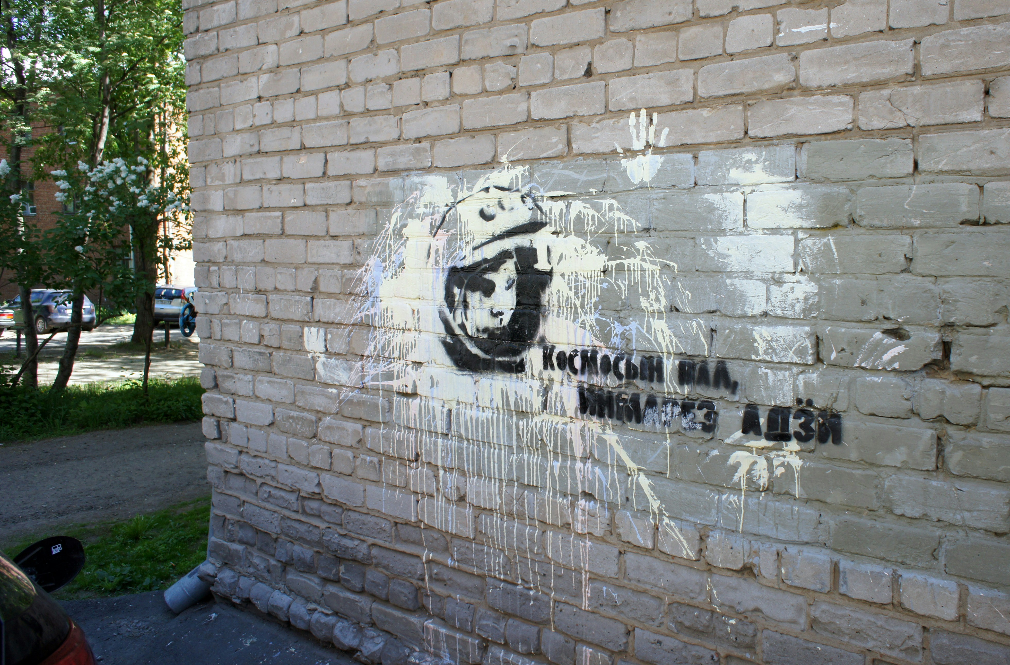 Graffiti Portrait on Weathered Brick: A Bleak Message in Sunlit Alley