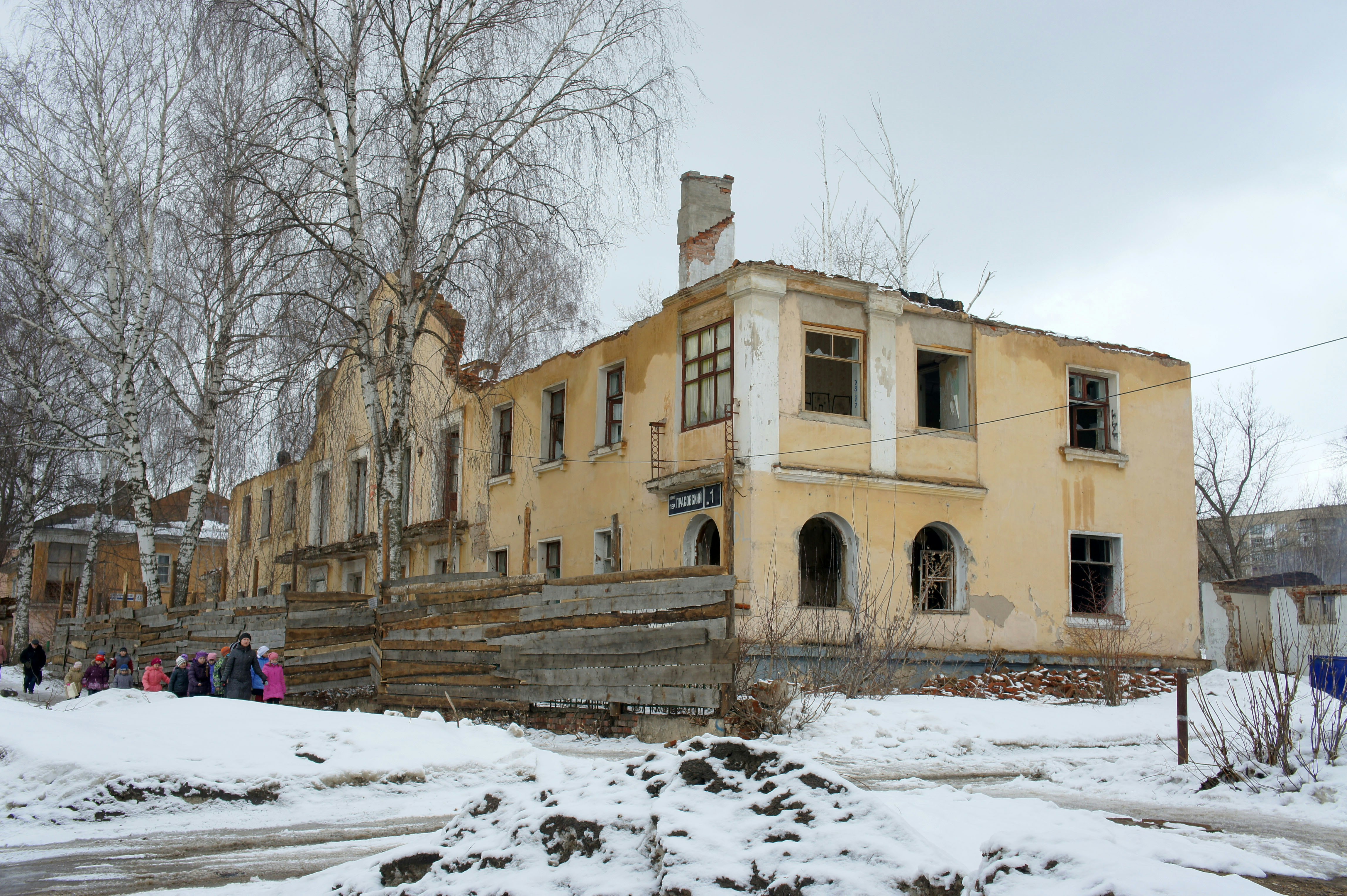 Deserted Yellow Facade: Snow Quiet Over an Abandoned House