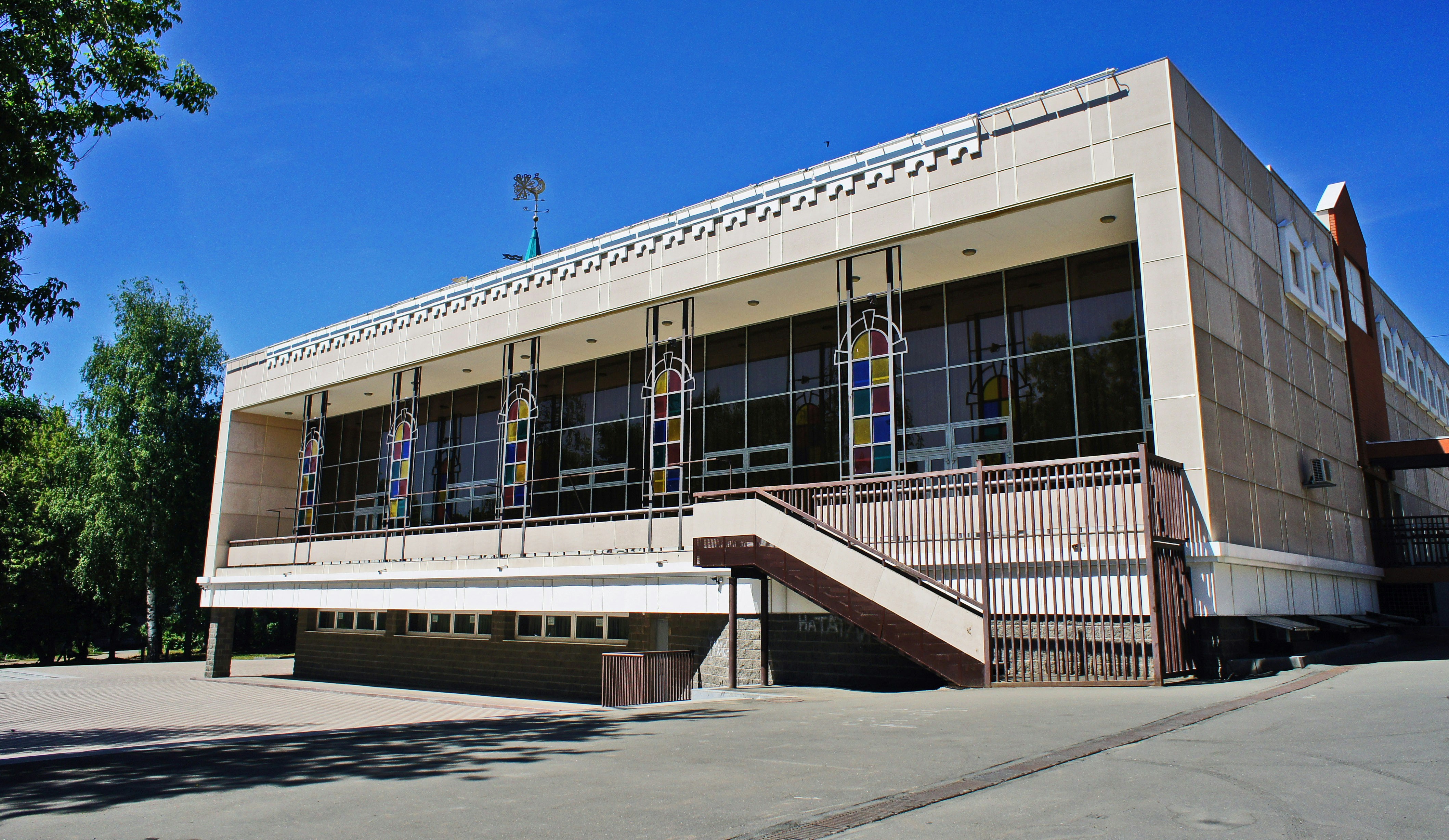Staircase to Glass: An Auditorium Facade Under Clear Sky