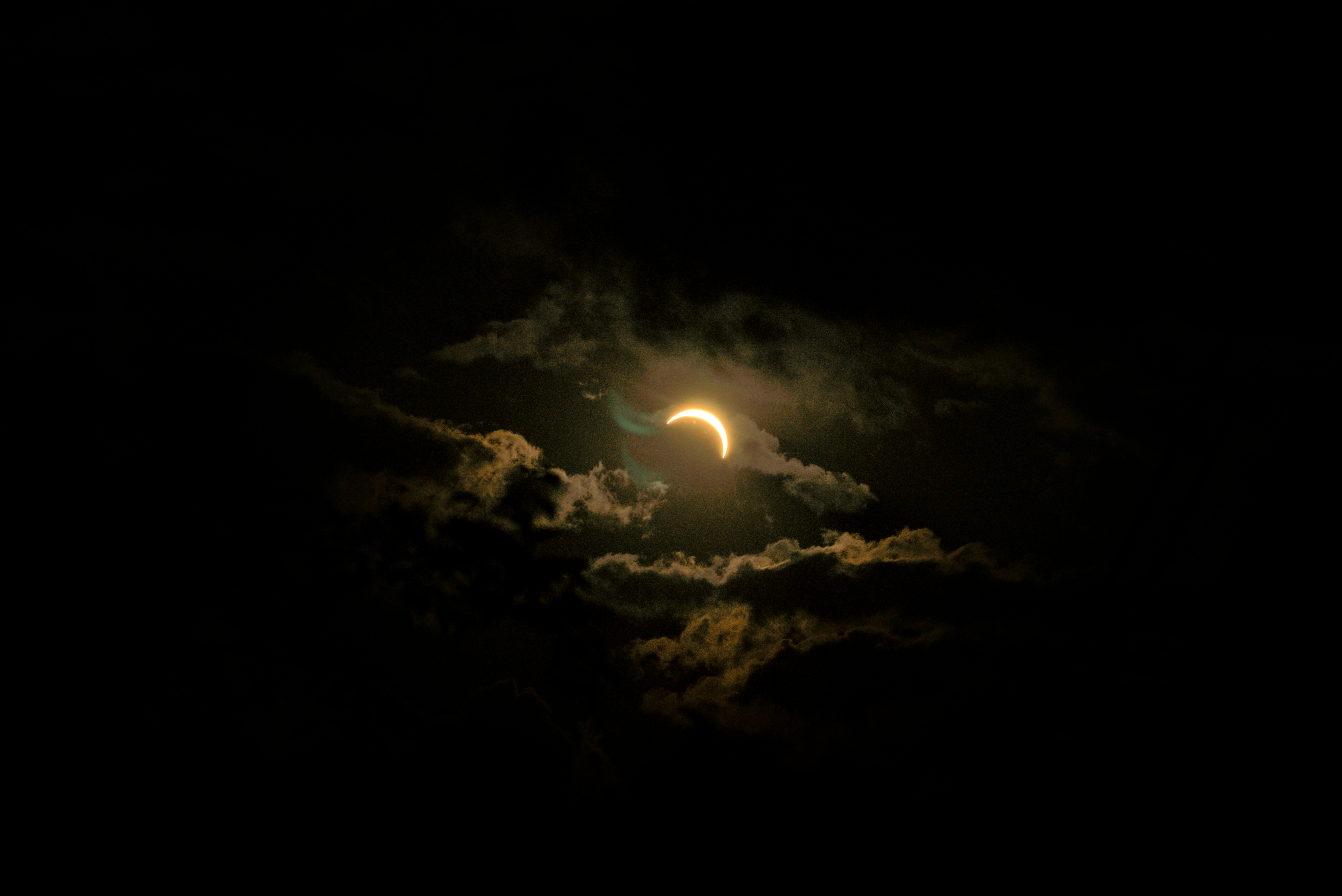 Eclipse of Silence: Crescent Moon Blink Through the Clouds