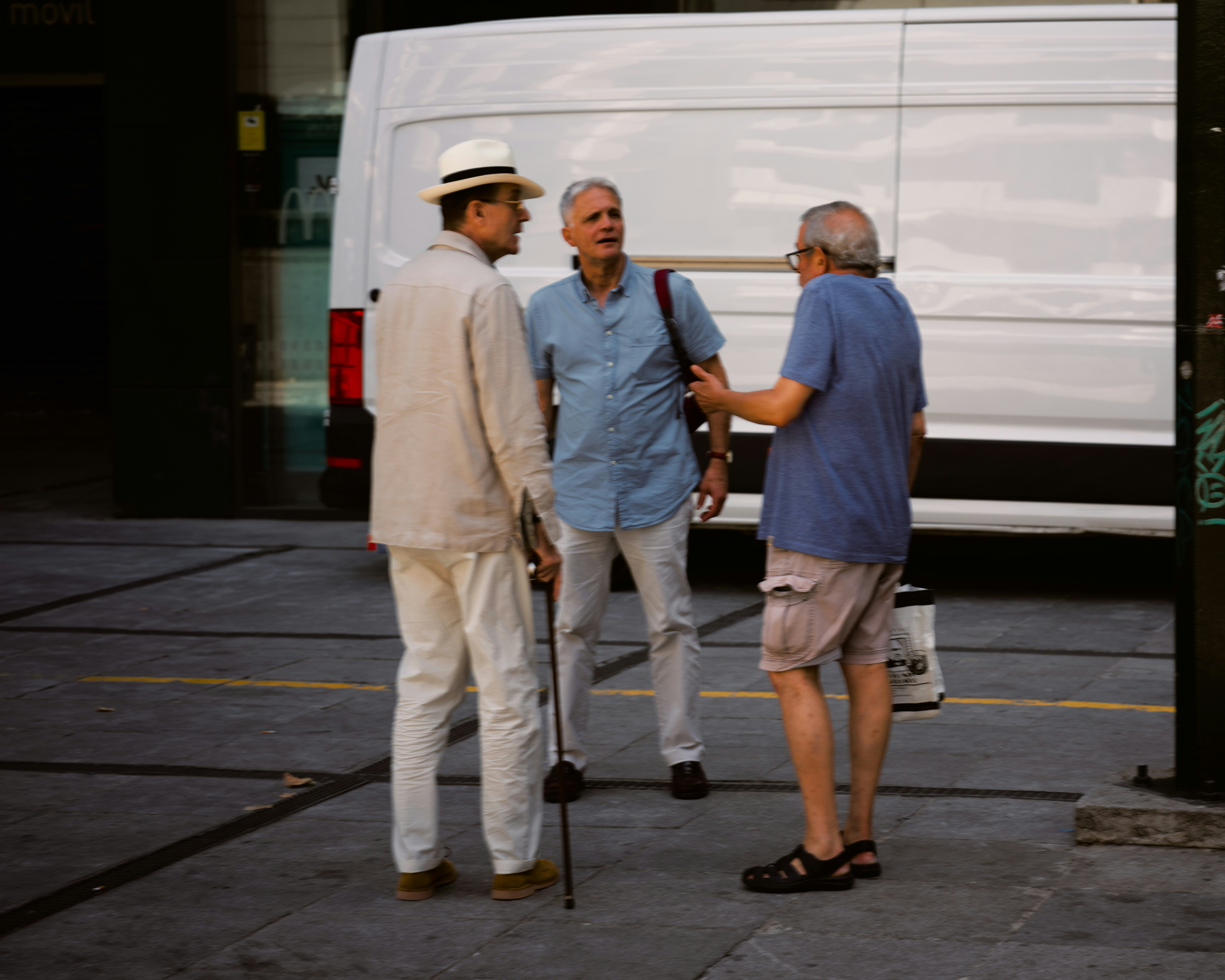 Three Men in Conversation by a Station Wagon