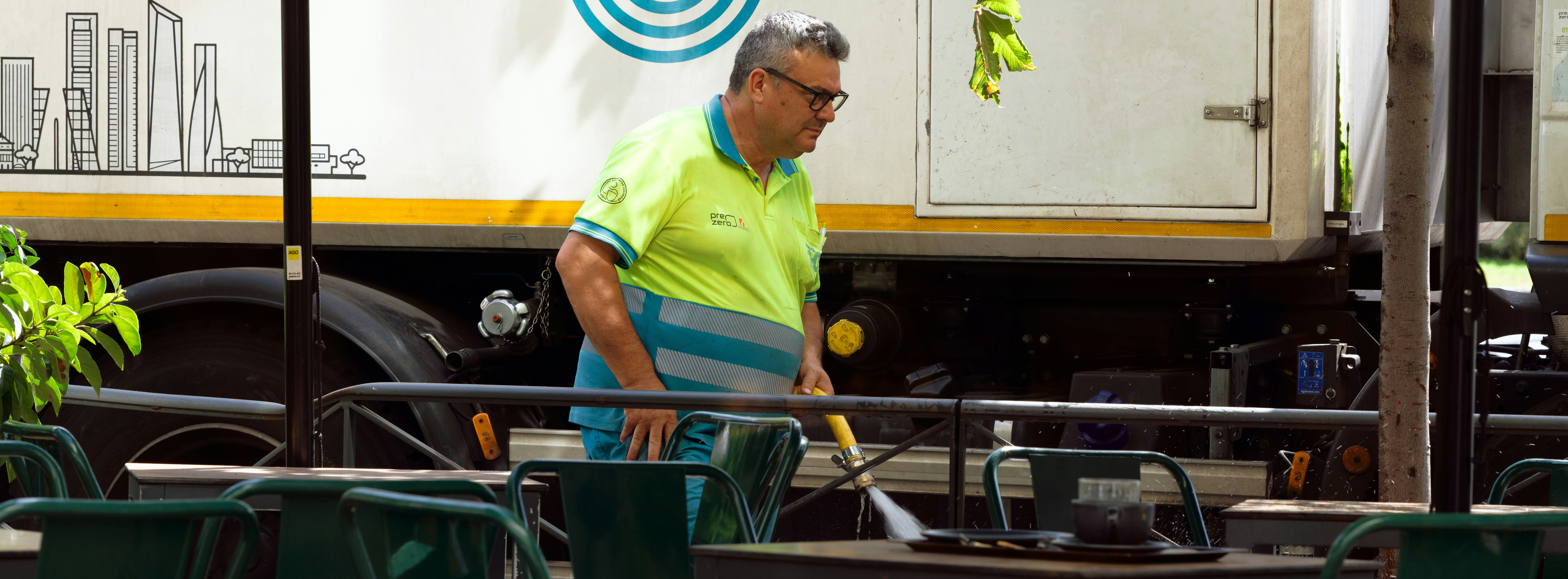 Worker in High-Visibility Shirt Inspects a Train Car on a Maintenance Lot