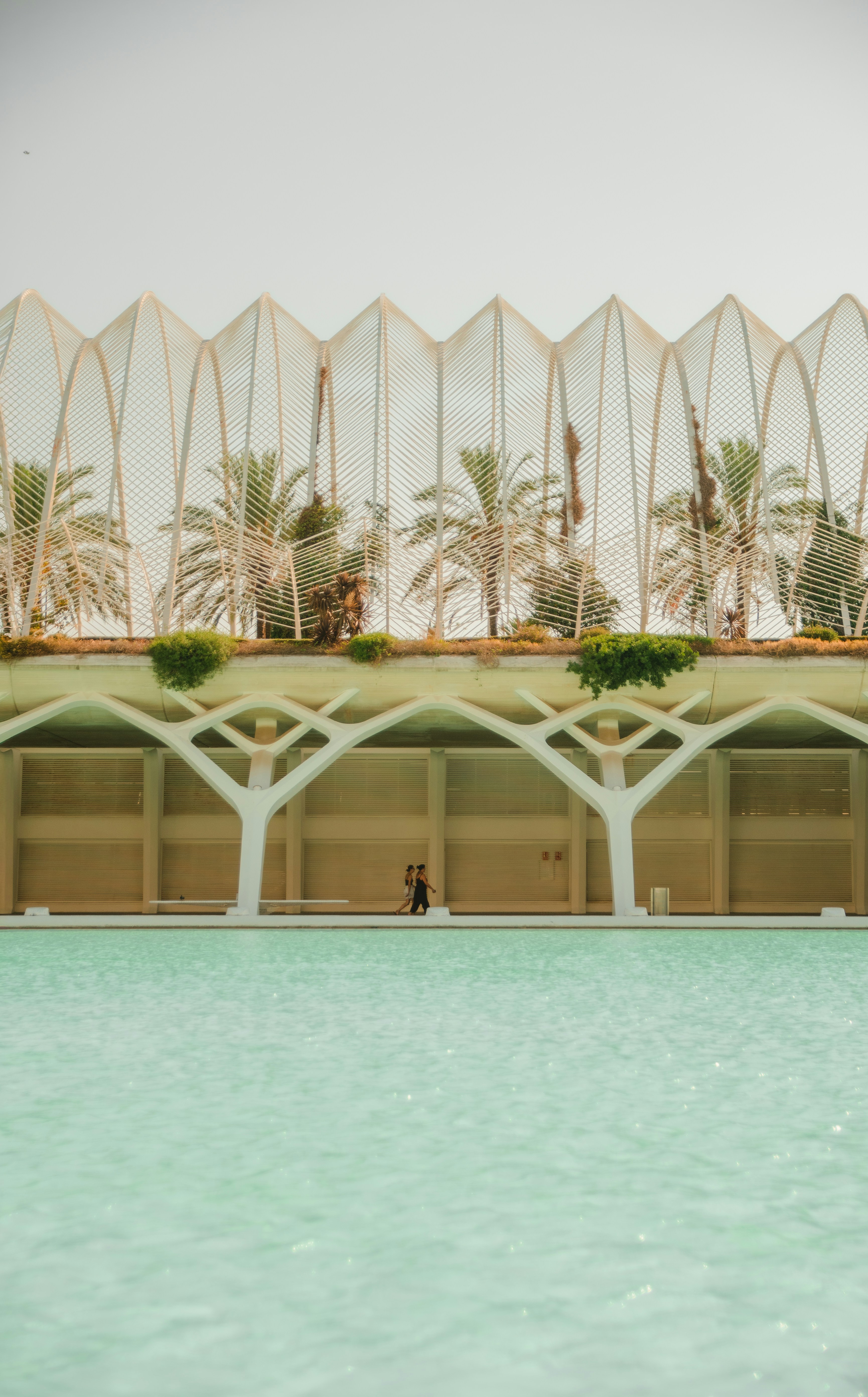 Geo-arched facade over turquoise calm: a quiet moment by the reefed pavilion