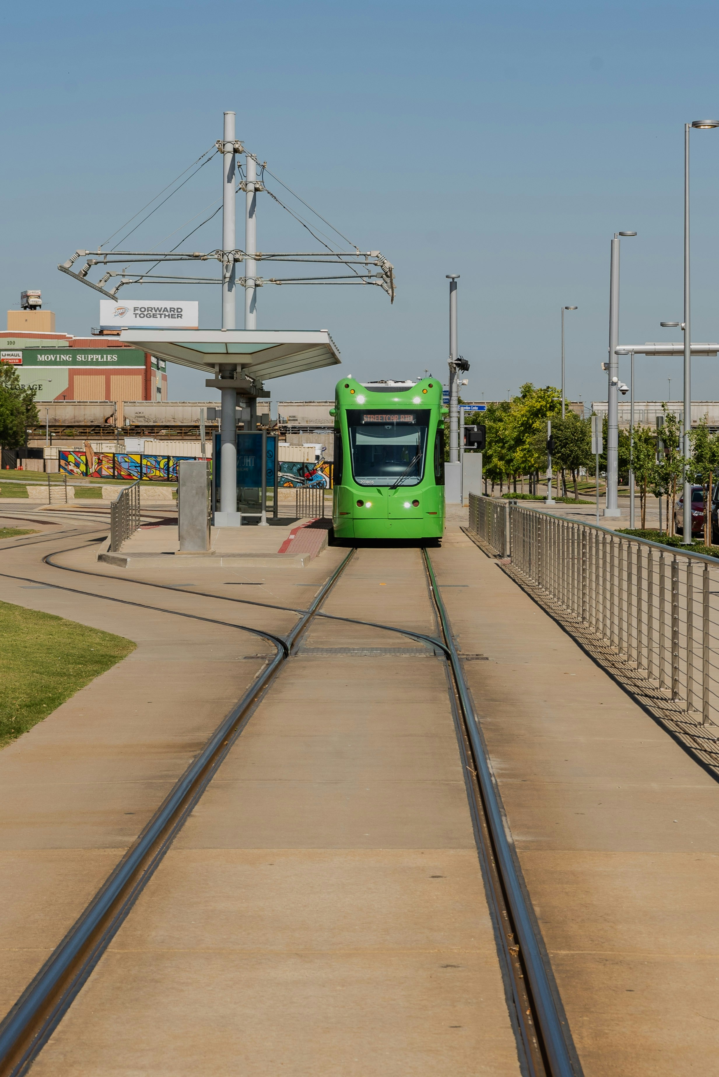 Bright Green Tram Pauses at a Modern Urban Station