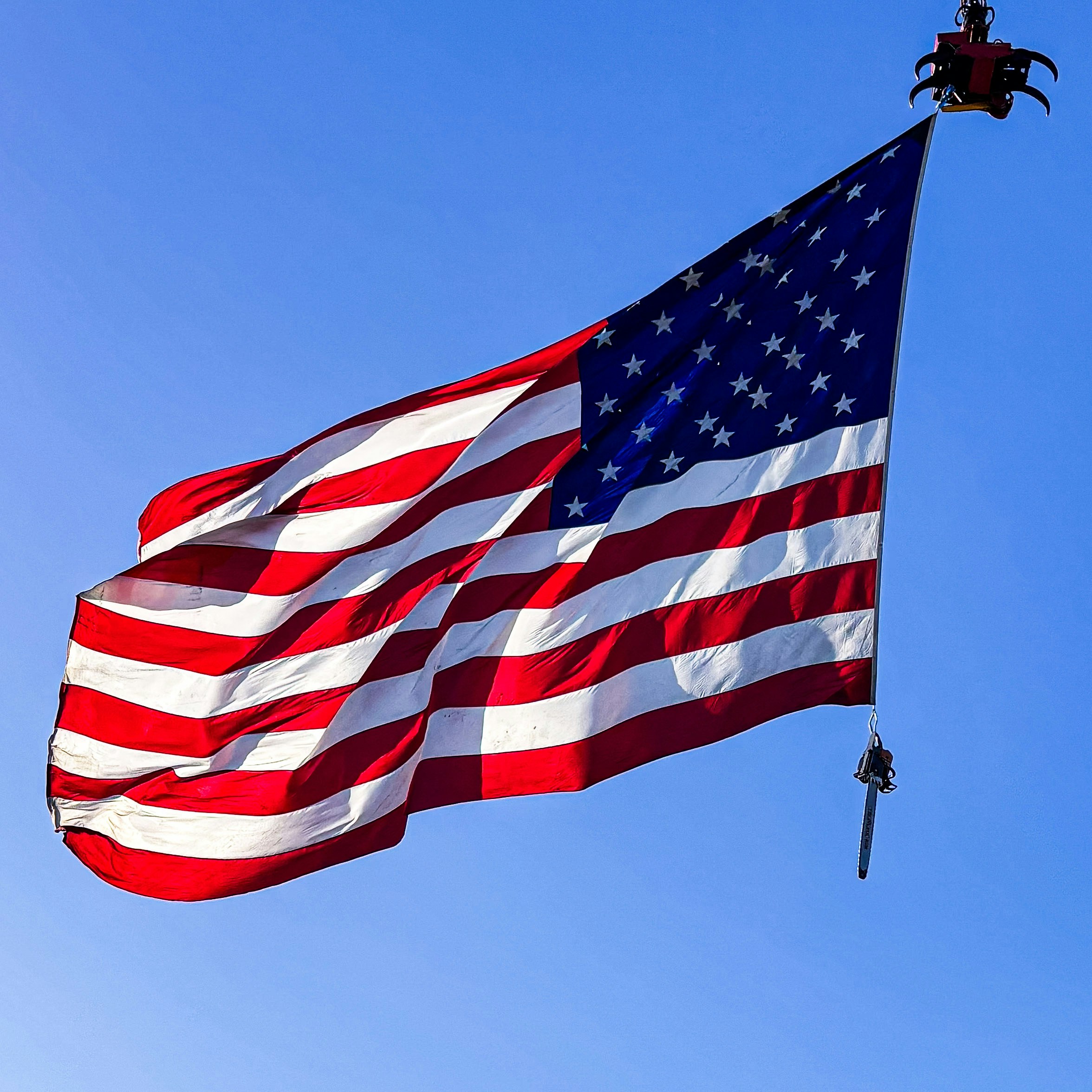 Freedom in the Wind: A Flag Whipped Across a Clear Sky