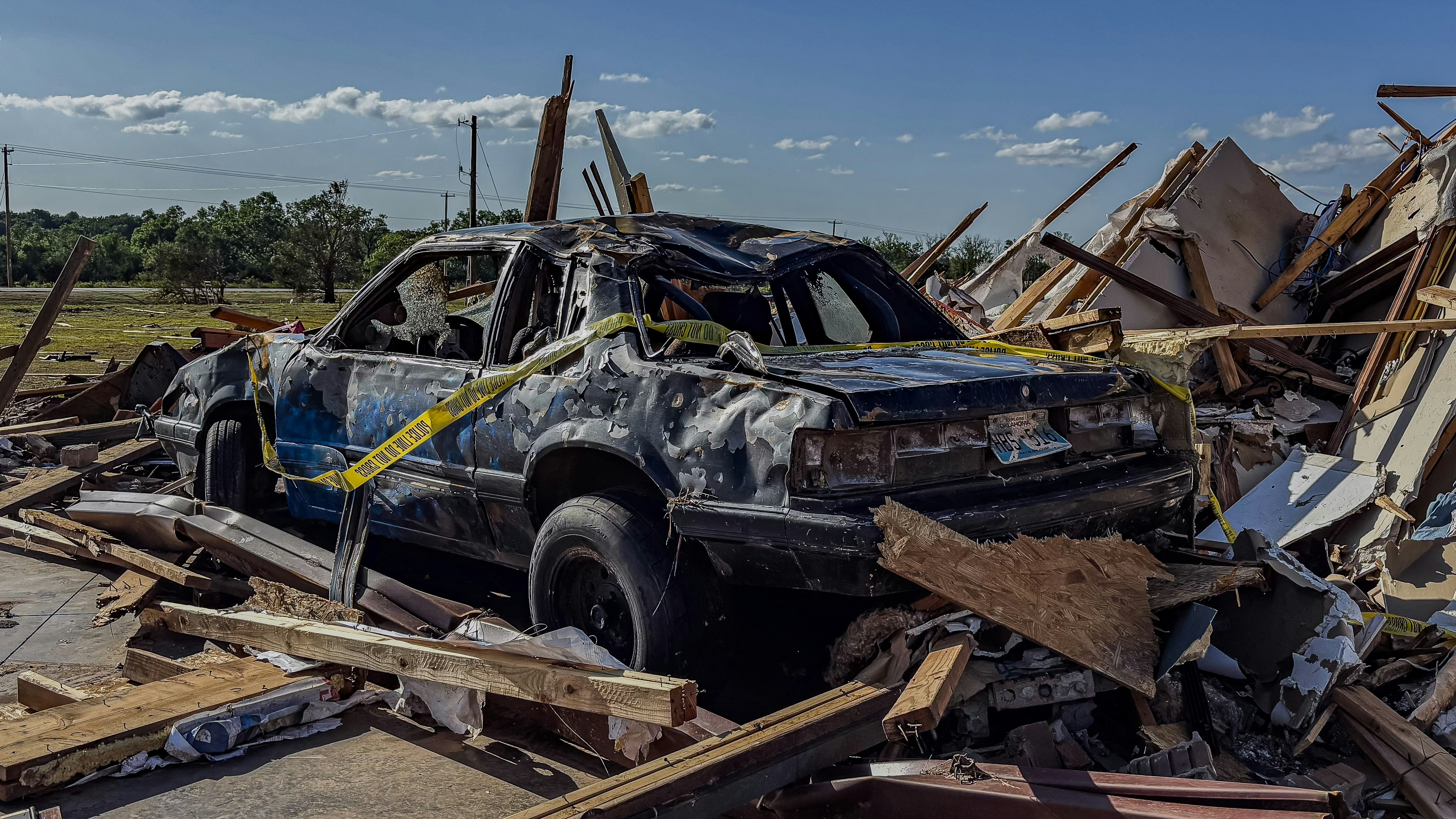 Collapsed aftermath: a mangled car buried under wreckage after the storm