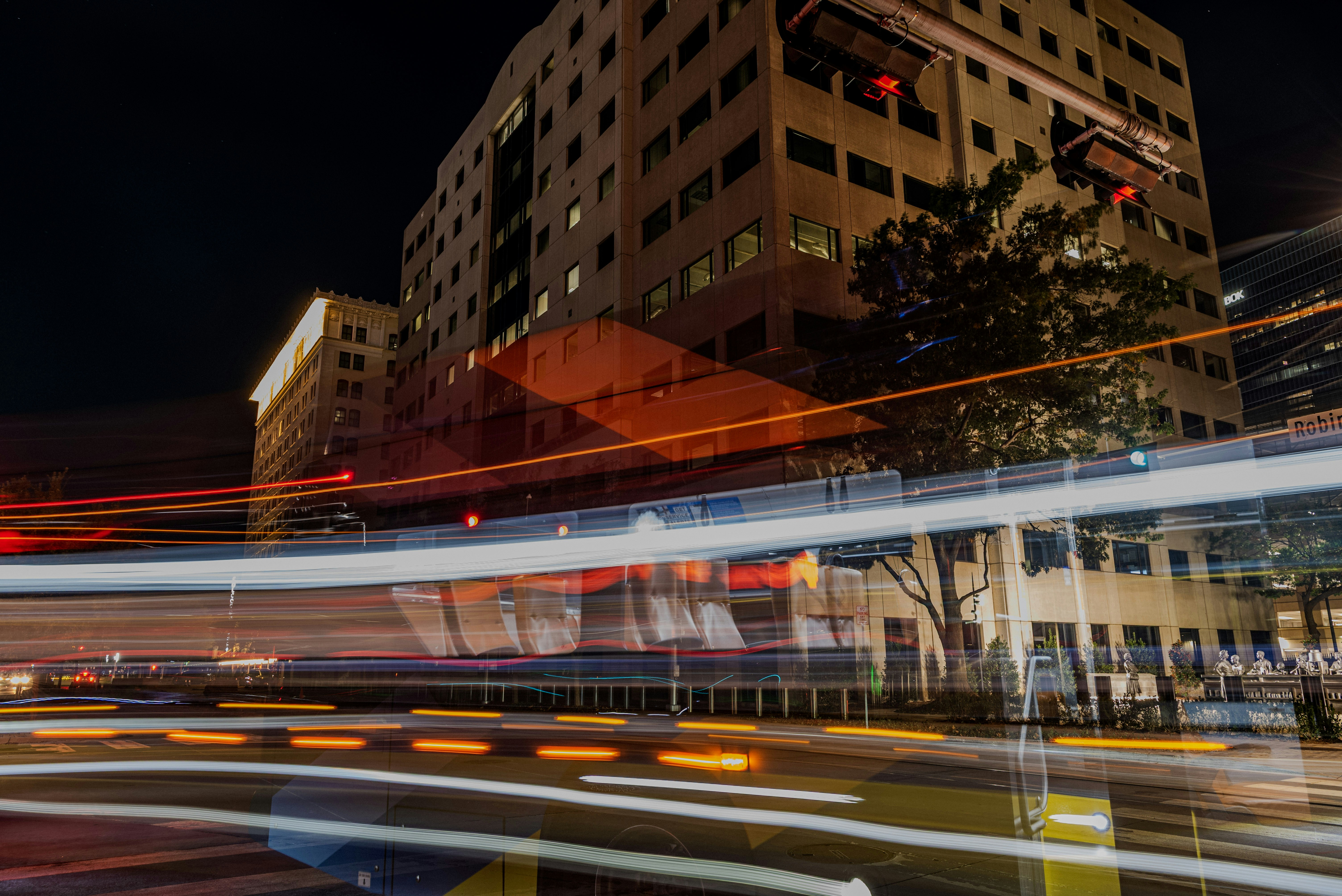 Street Light Trails Across a Night City Facade