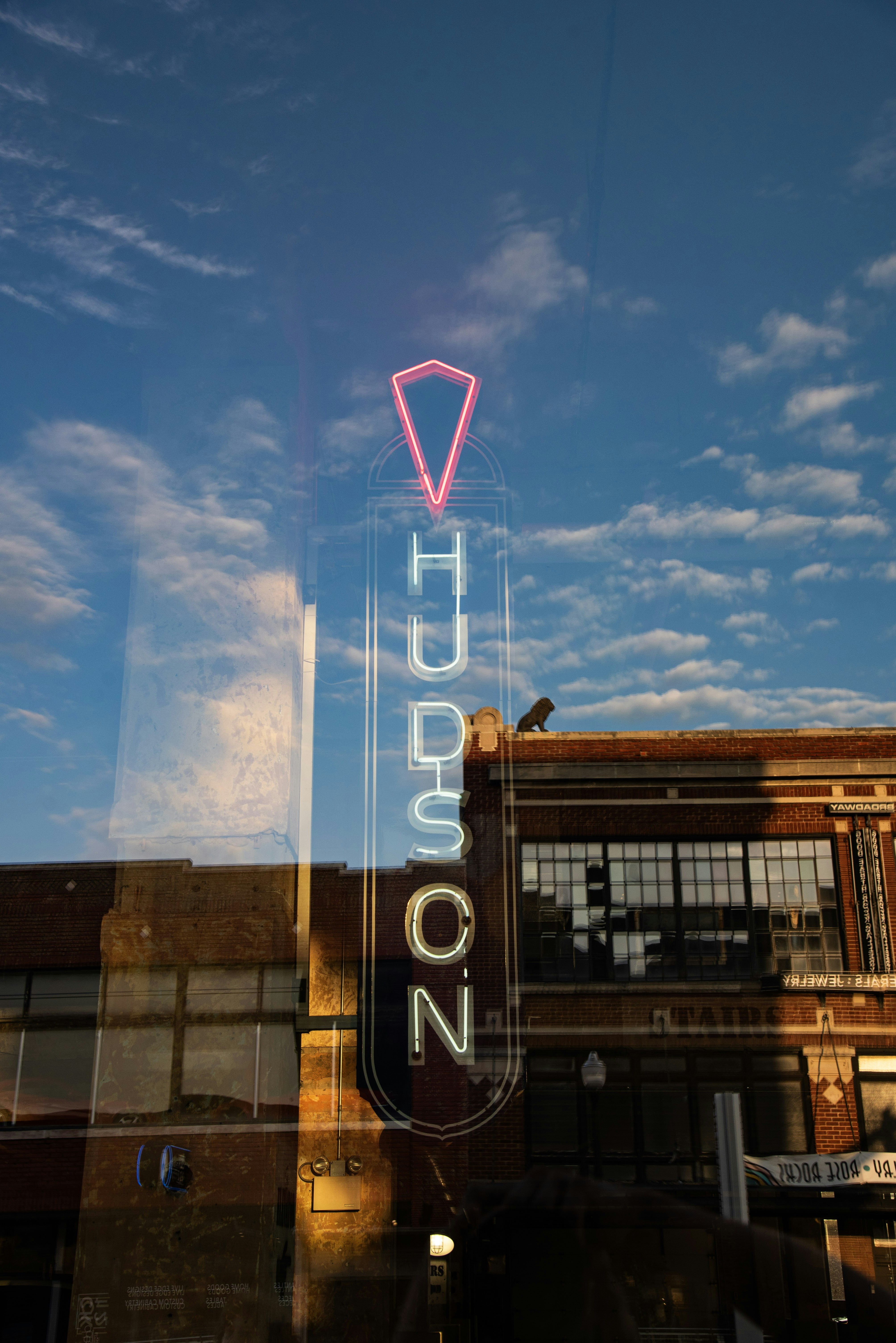 Neon Pedestal: A Vertical Sign Illumination Reflected in Glass