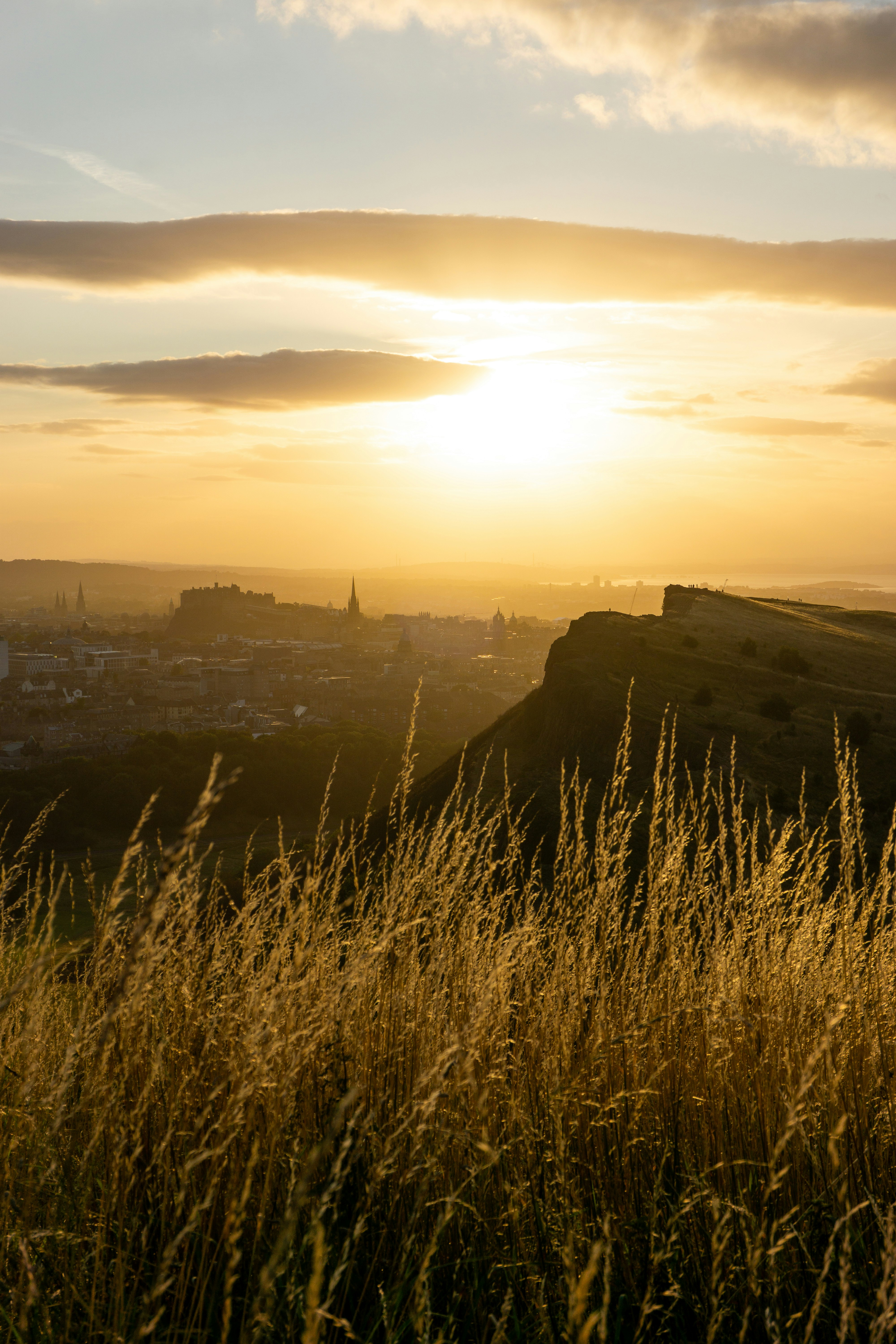 Golden Ridge at Dusk: Sunlit Hills and City Silhouette