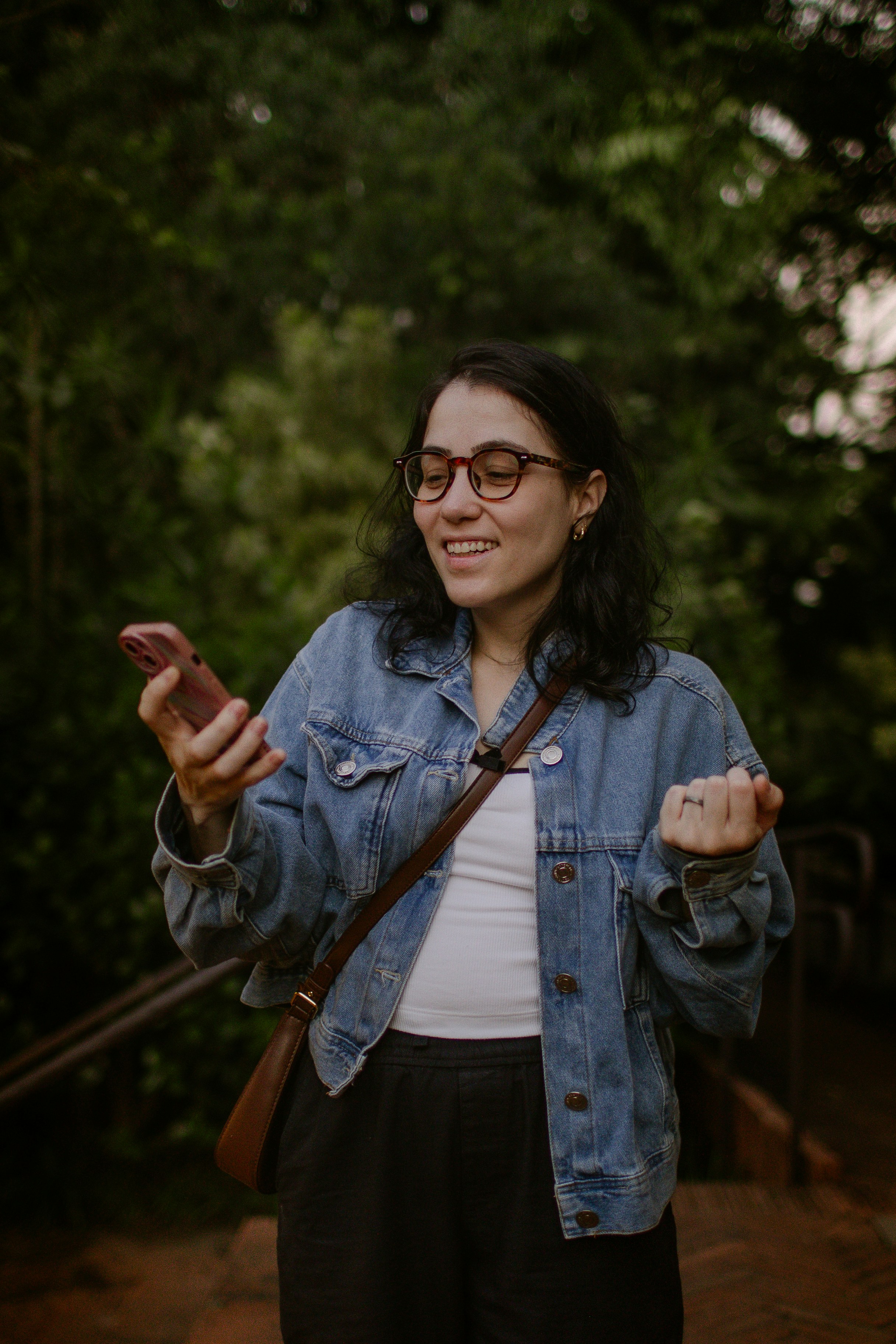 Casual conversation on a sunlit trail: denim jacket and smartphone glow