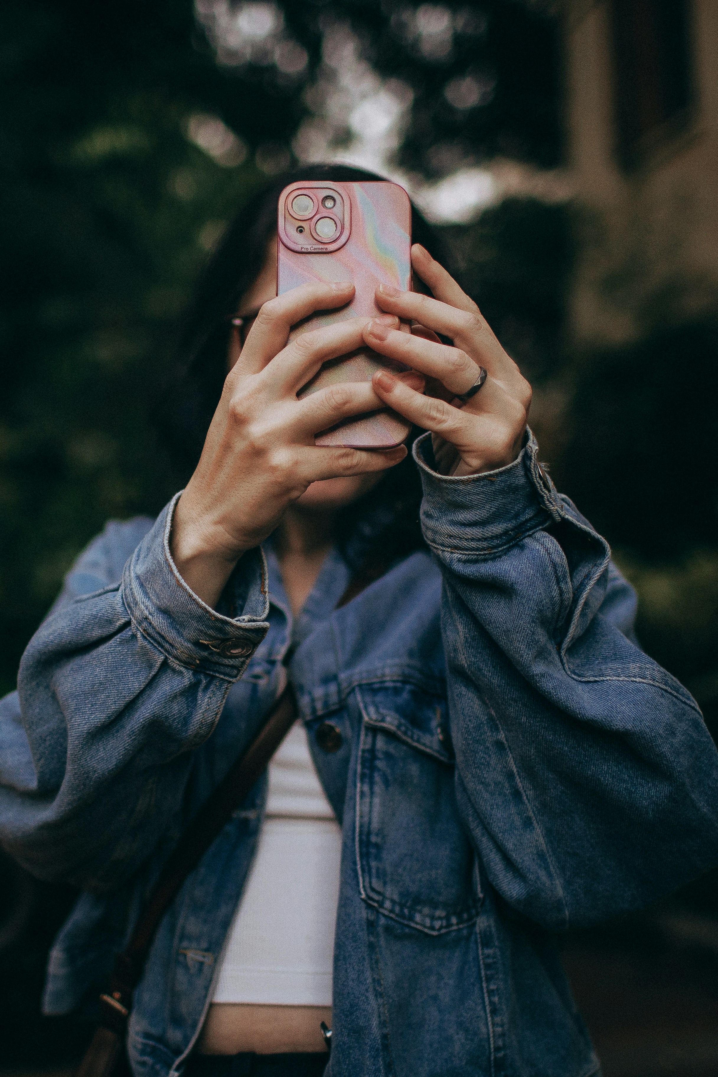 Selfie in Focus: A Denim Moment with Colorful Glass on Camera