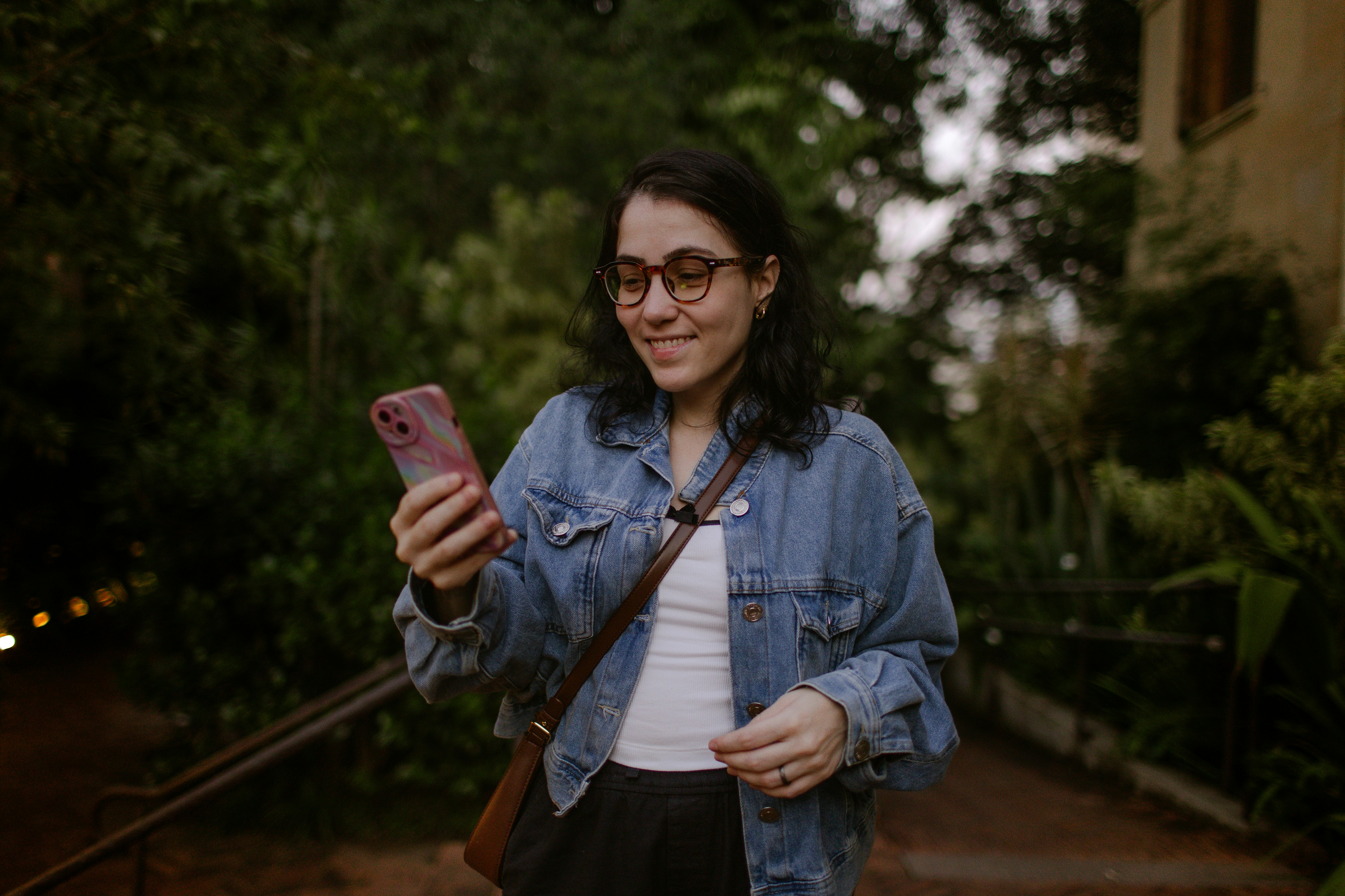 Portrait in Motion: A woman Photoscanning with a pink smartphone along a garden path