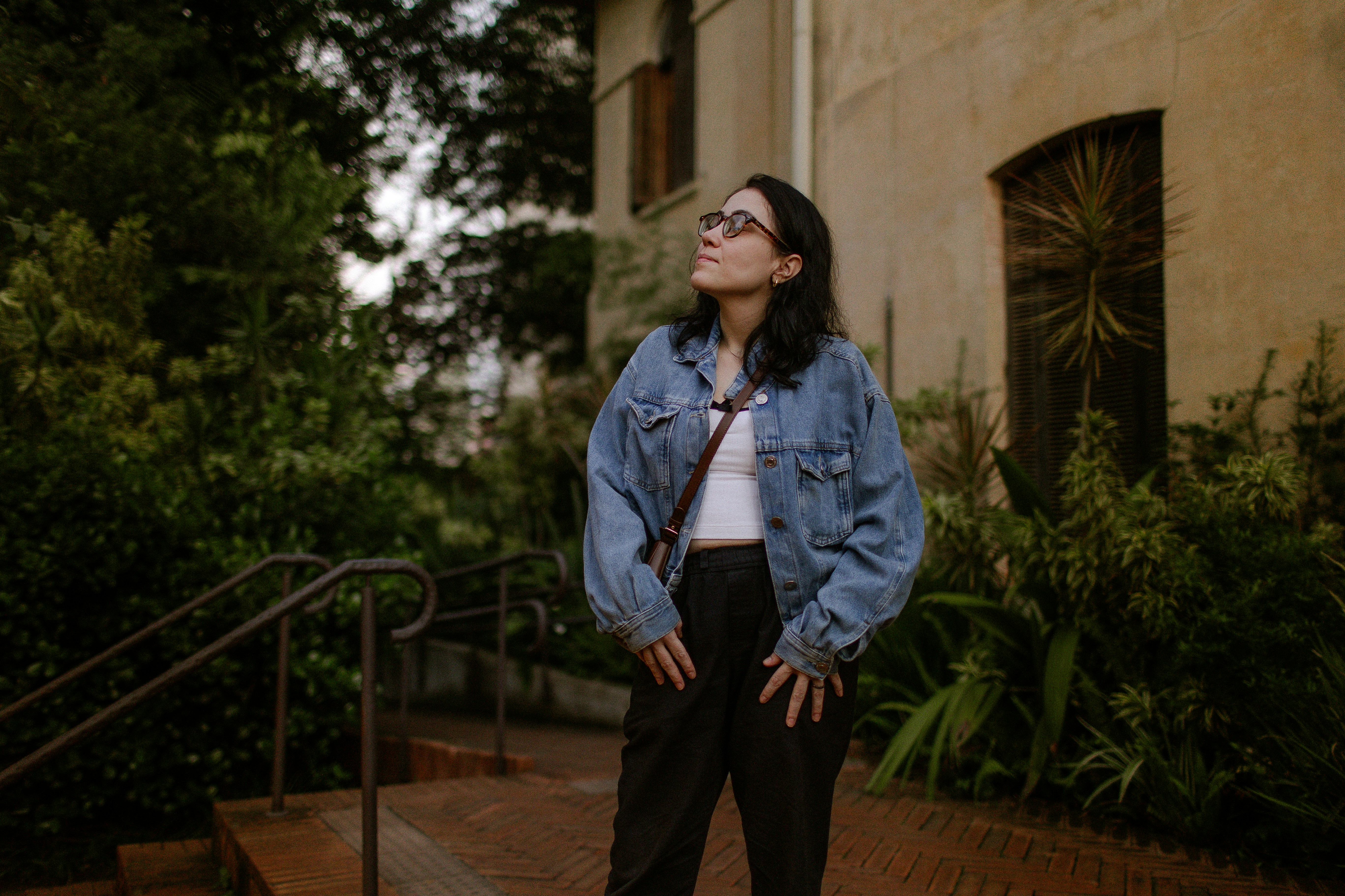 Urban portrait in dappled light beneath a vintage facade