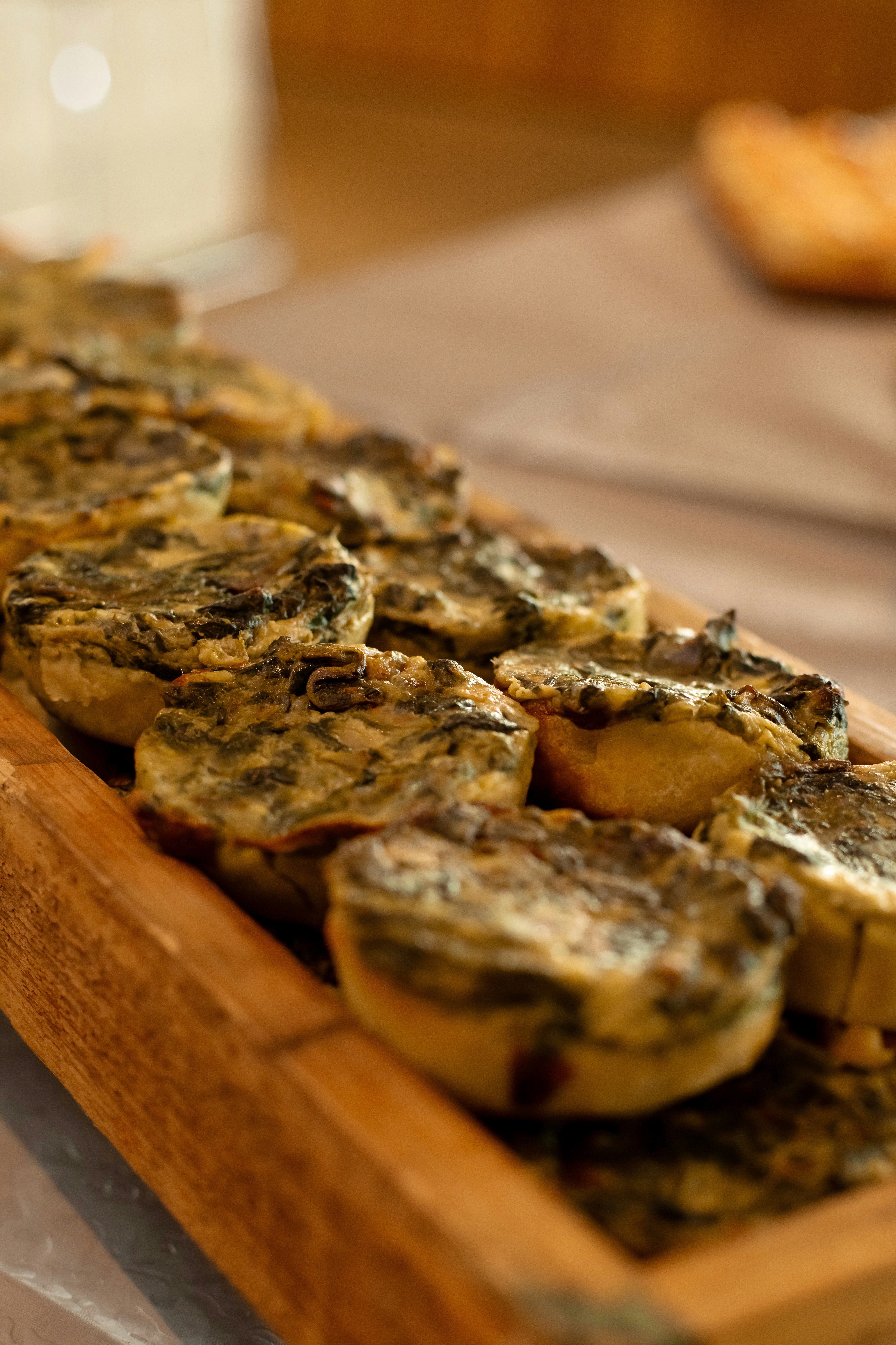 Row of savory mushroom-filled pastries on a wooden serving board