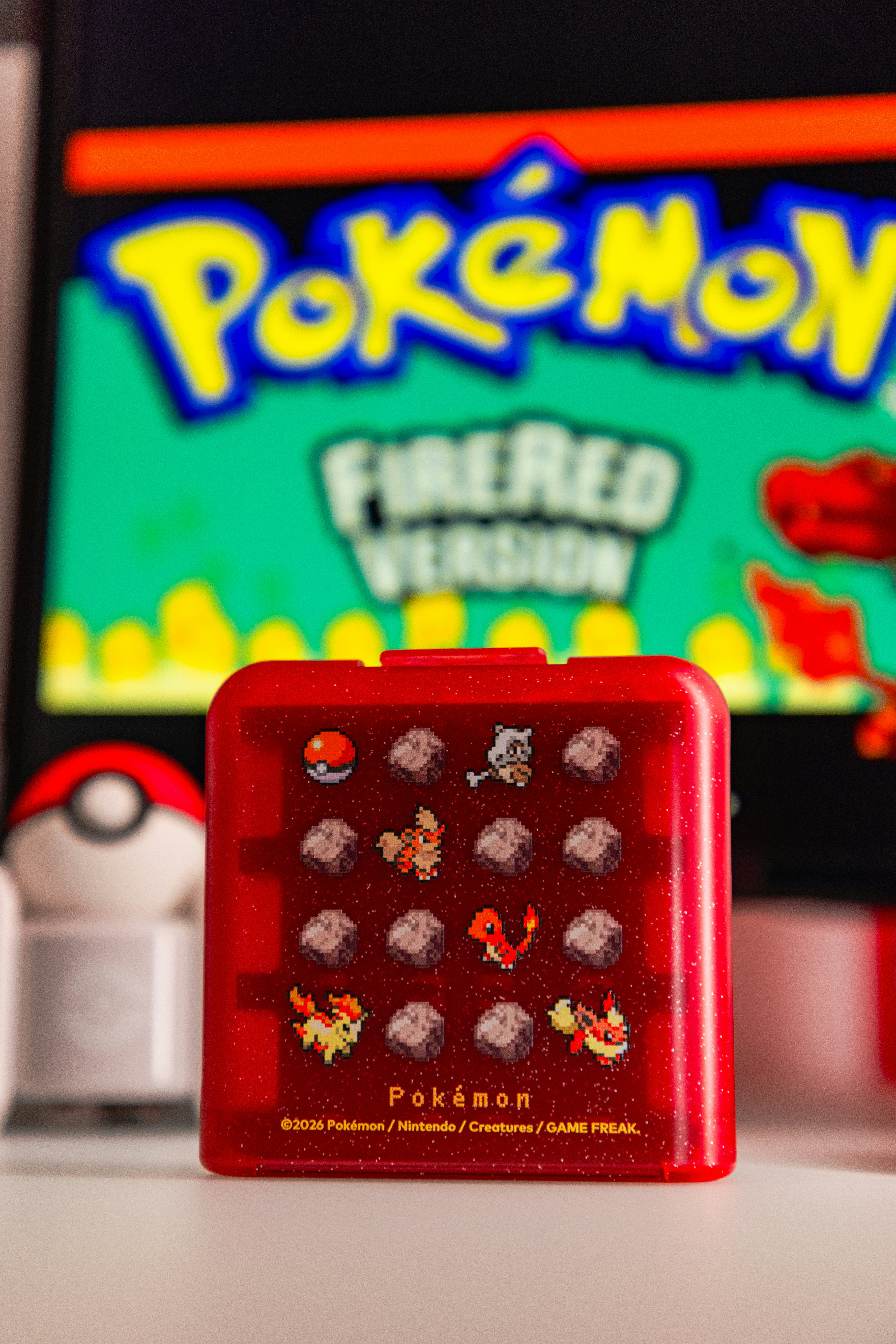 Red Pocket Pixel Playground in Front of a Pixelated Pokémon Display