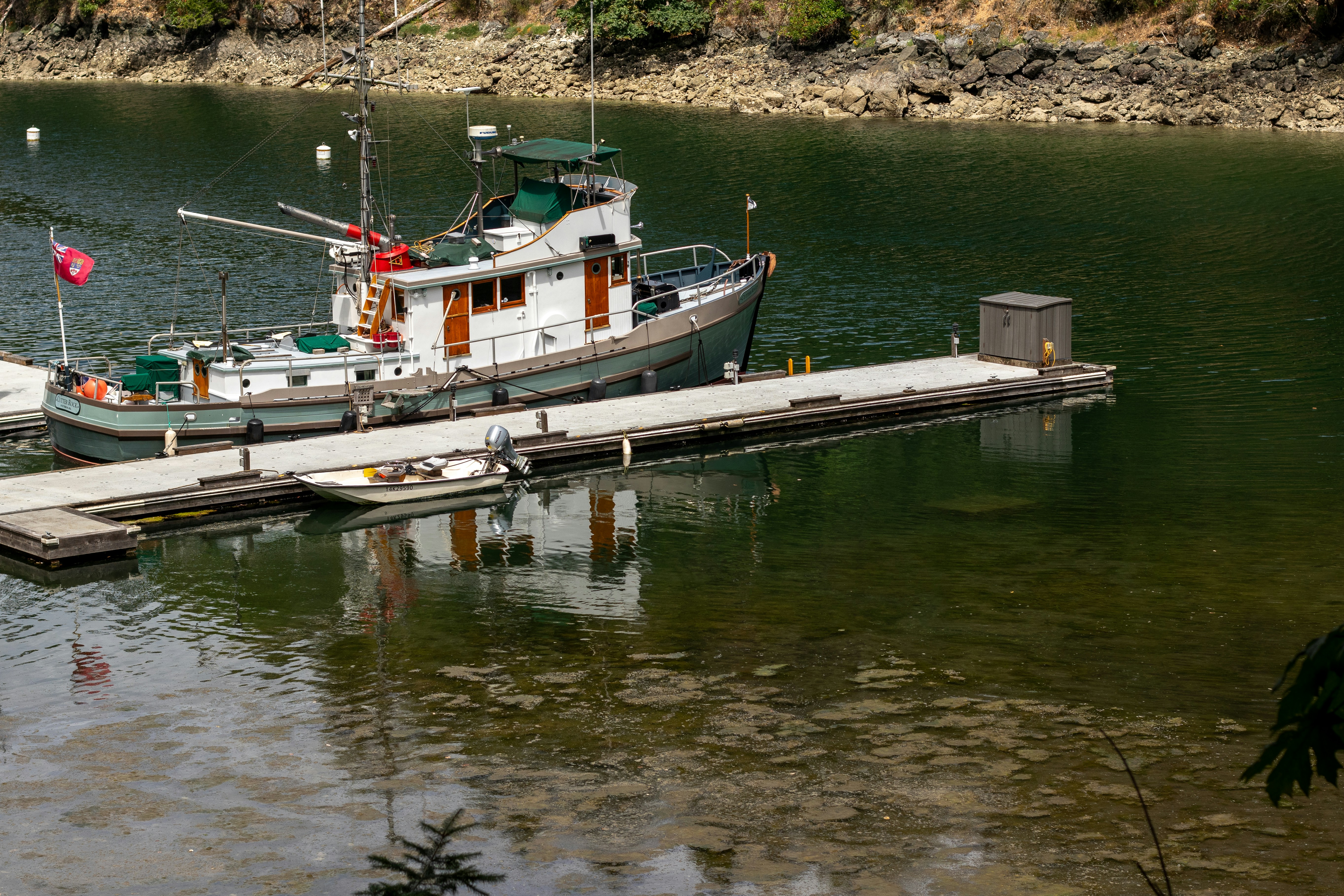 Docked Vessel at Quiet Marina: A Sailboat and its Reflection