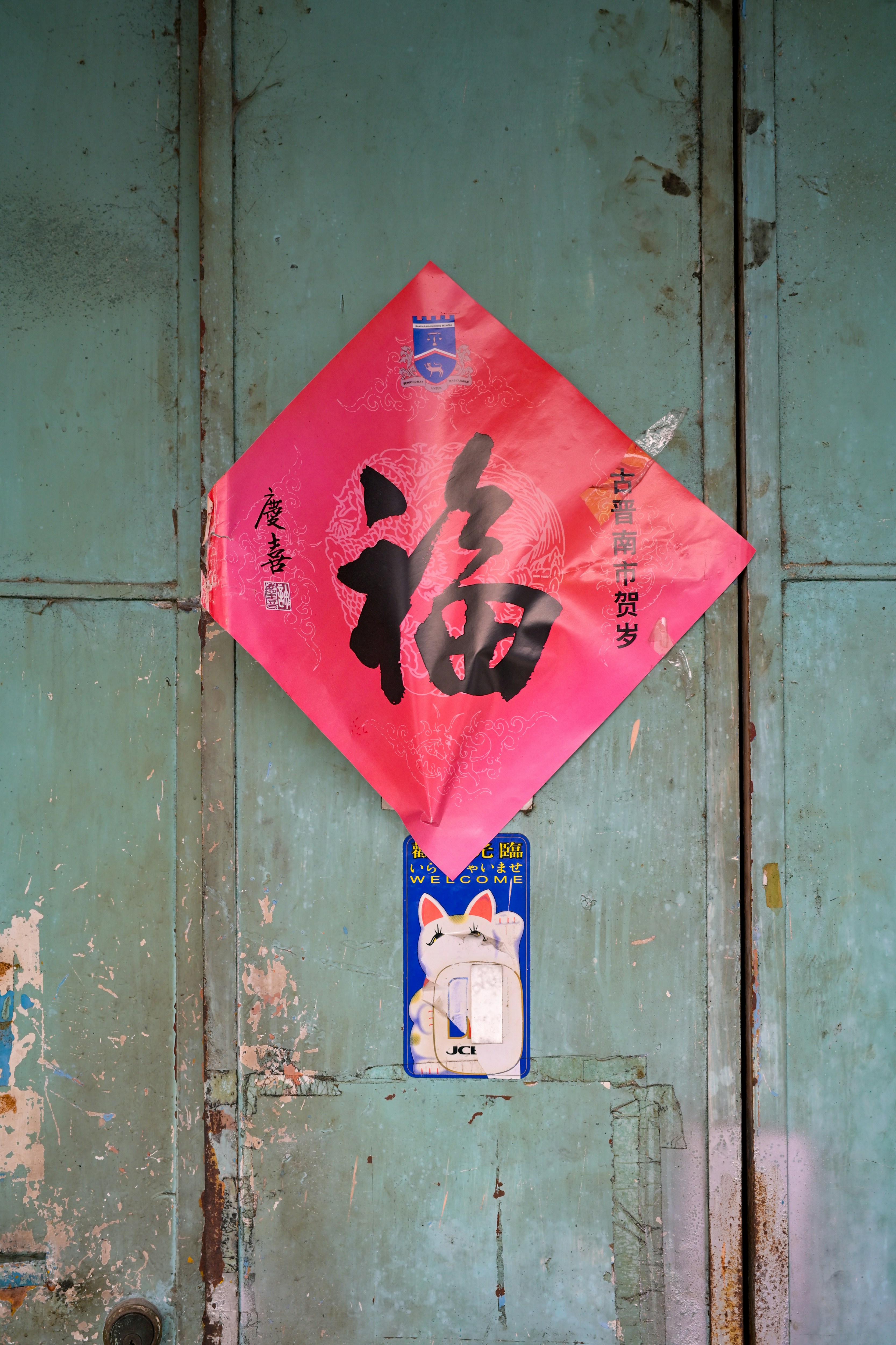 Red Diamond Greeting: A Hinged Red Charm on Weathered Green Doors