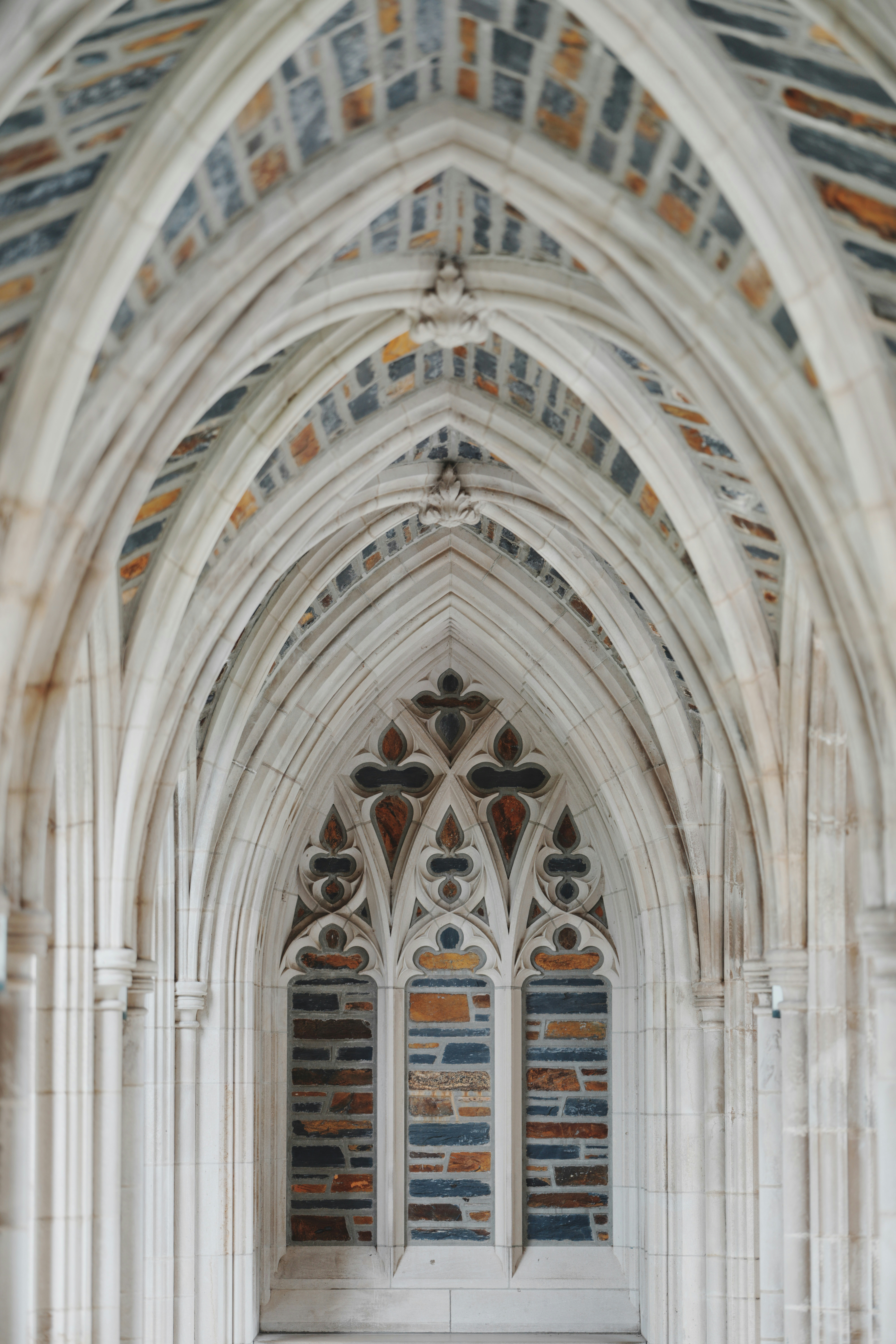 Gothic Archways and Stained Glass Windows in a Medieval Corridor
