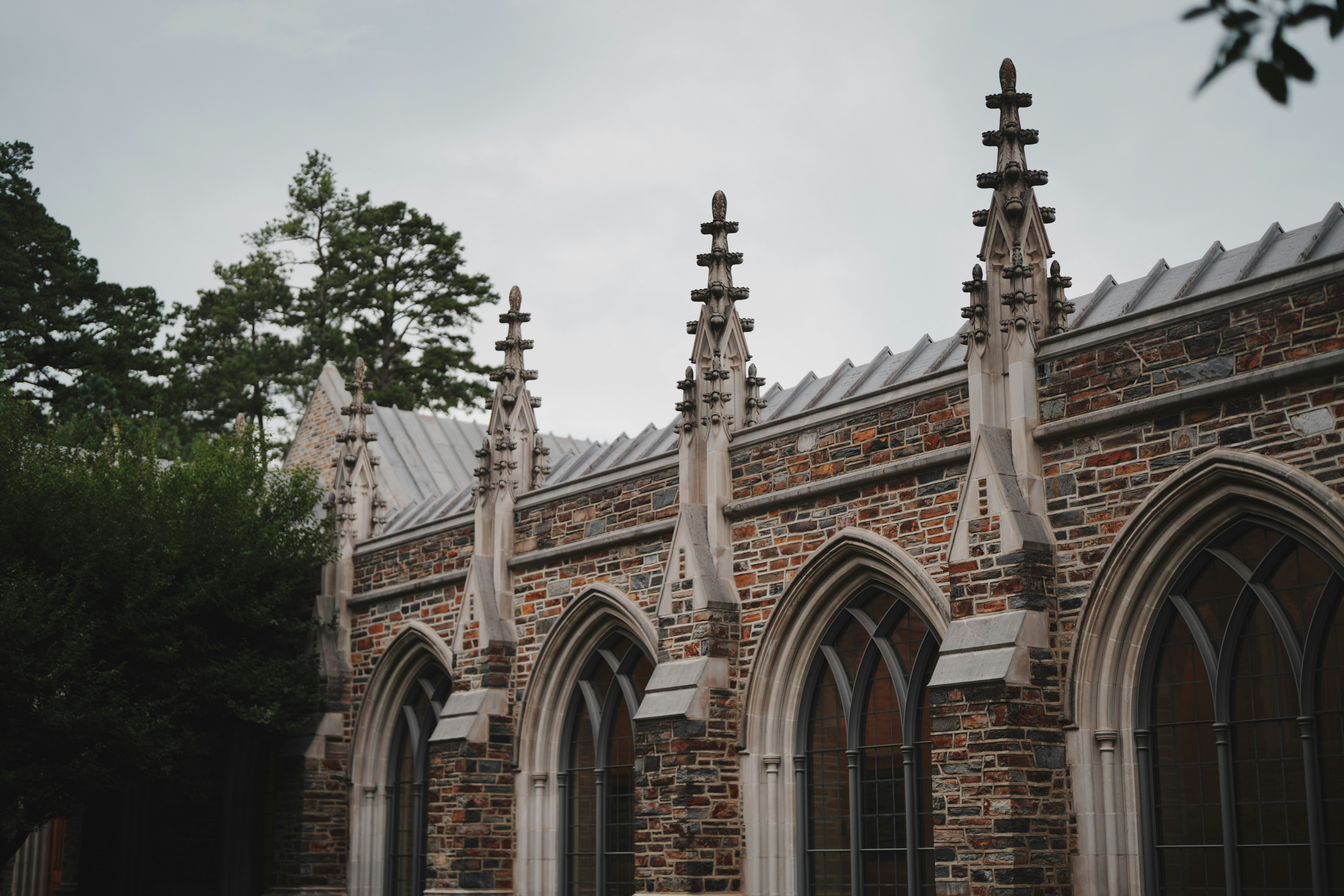 Stone Gothic Facade: Arched Windows and Pinnacles Against a Growing Sky