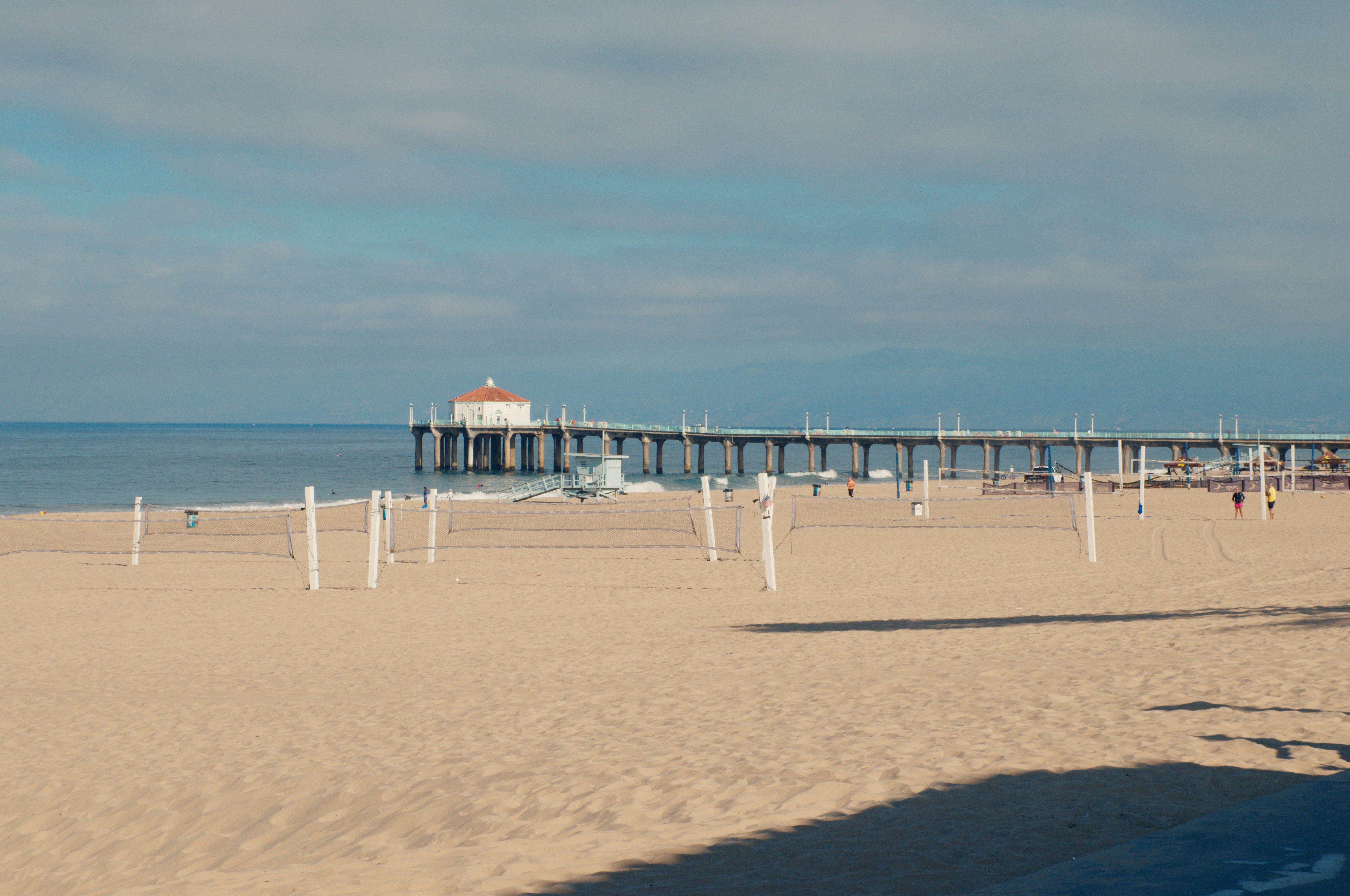 Pier at Distant Horizon: Quiet Beach with a Red-Topped Pavilion
