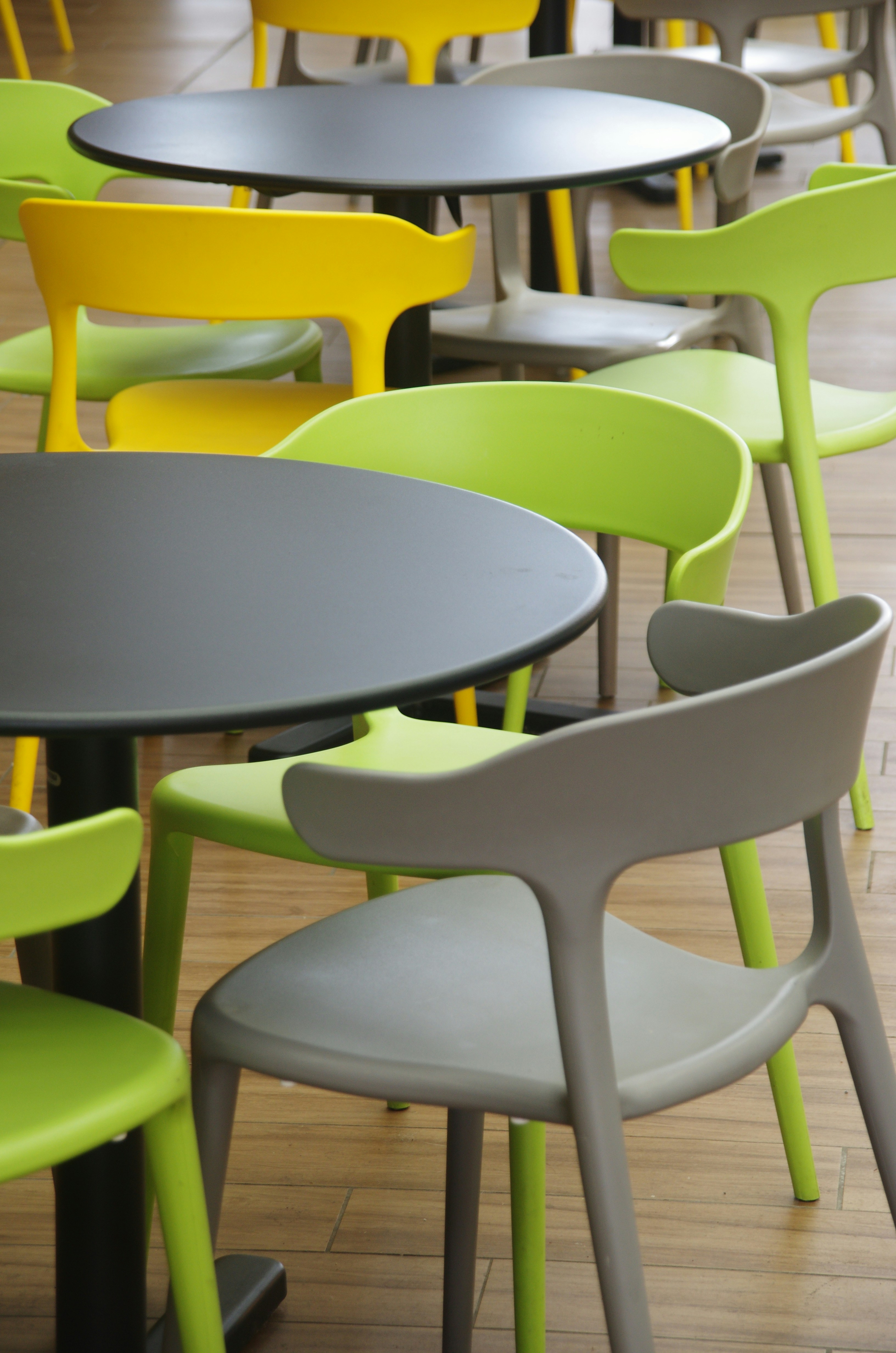 Colorful Café Ensemble: Modern Chairs Nestled Around Round Tables