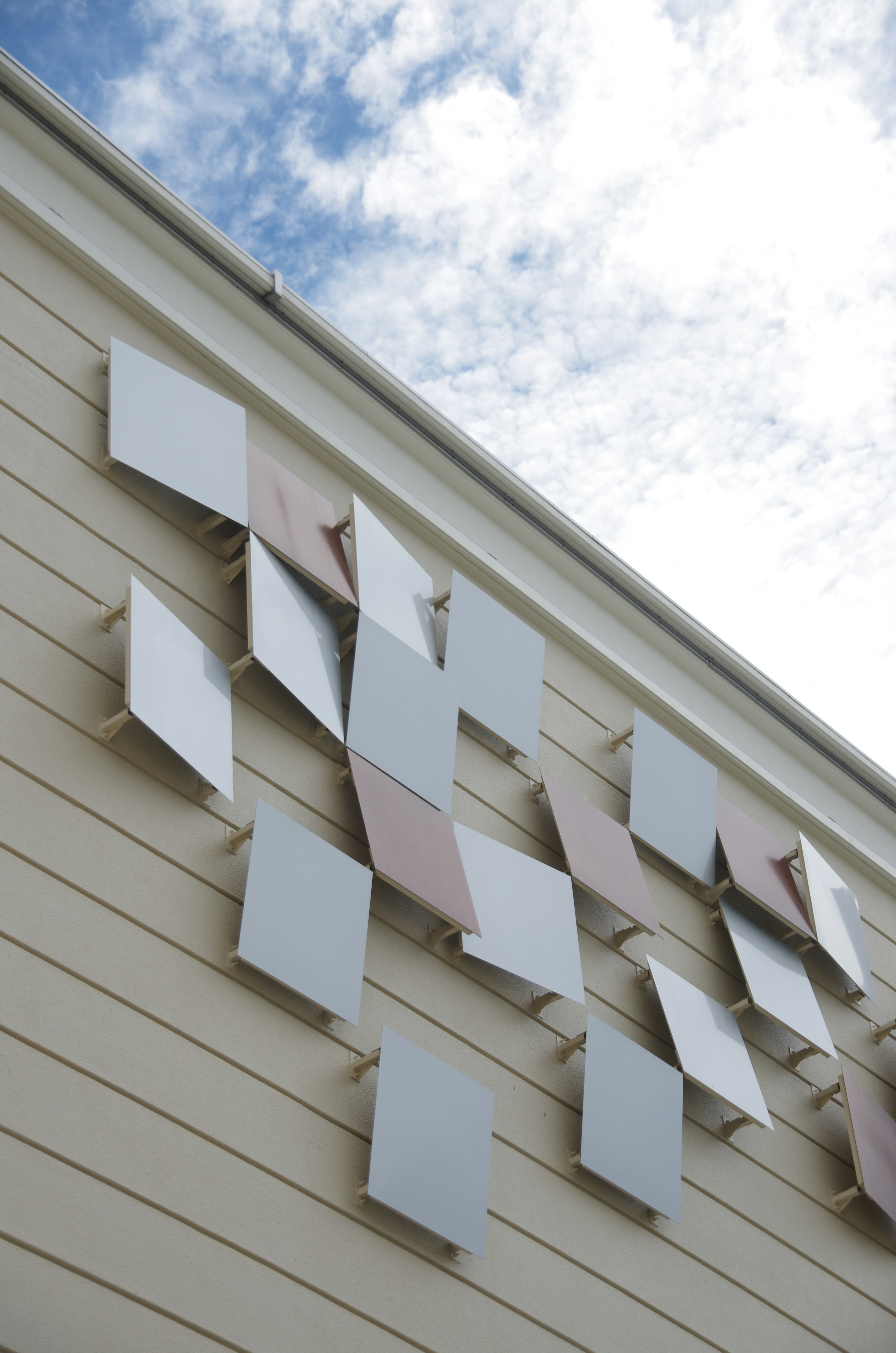 Geometric tiles on a sunlit house facade echoing a modern mosaic