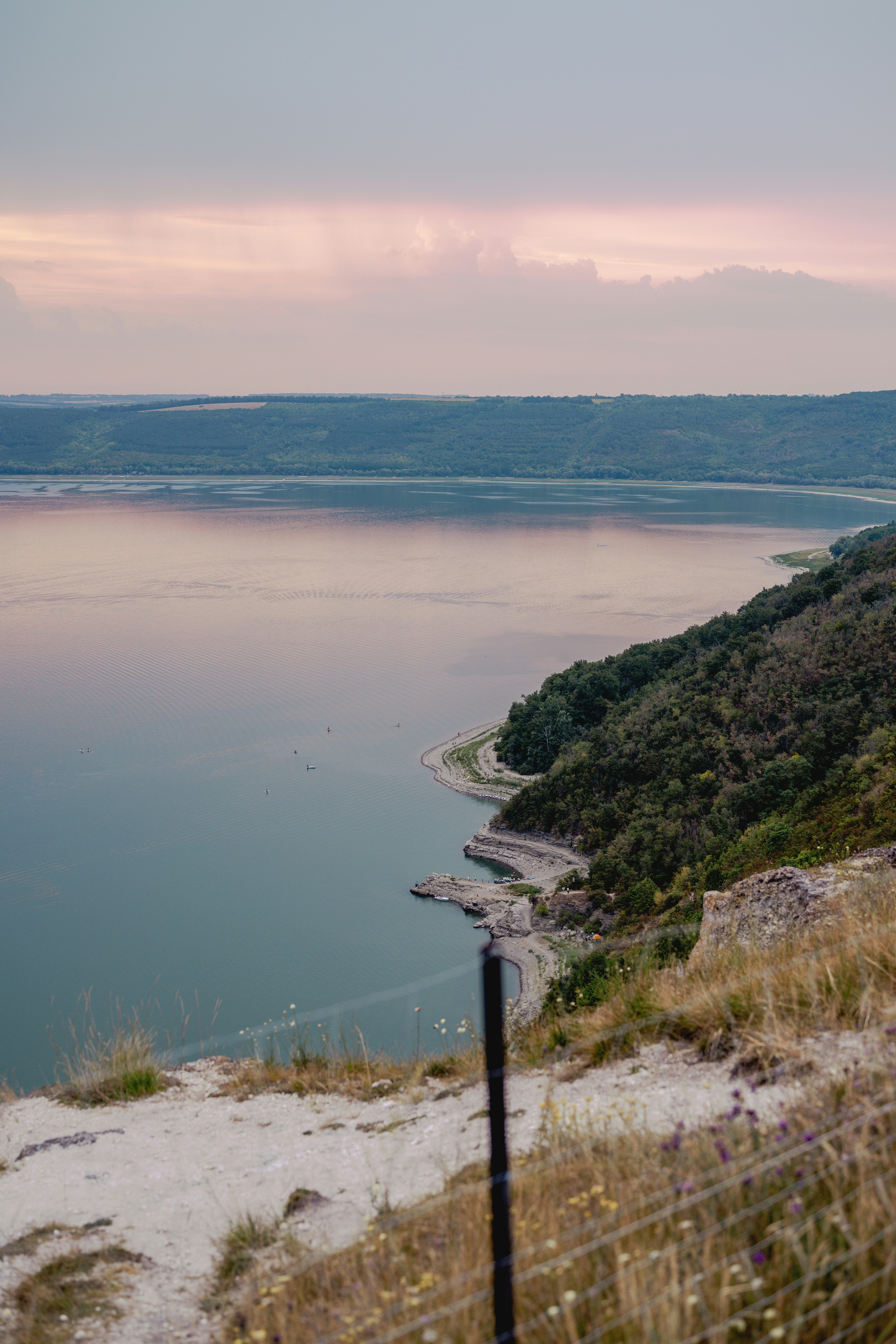 Riverbend Vista at Dusk: Cliff, Water, and Framing Fence